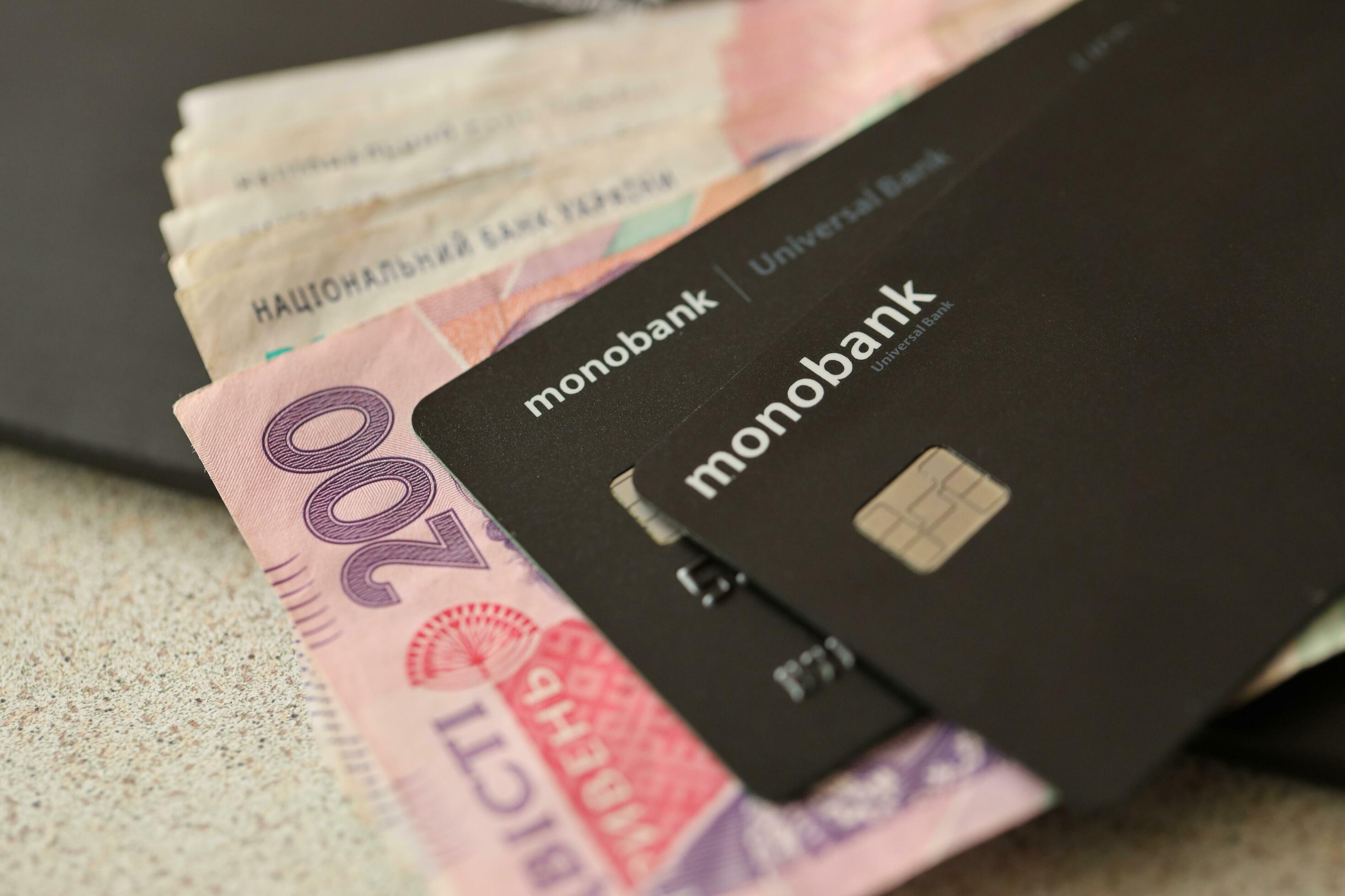 KYIV, UKRAINE - JULY 7, 2023 Monobank banking plastic cards with money on table 29620706 Stock ...