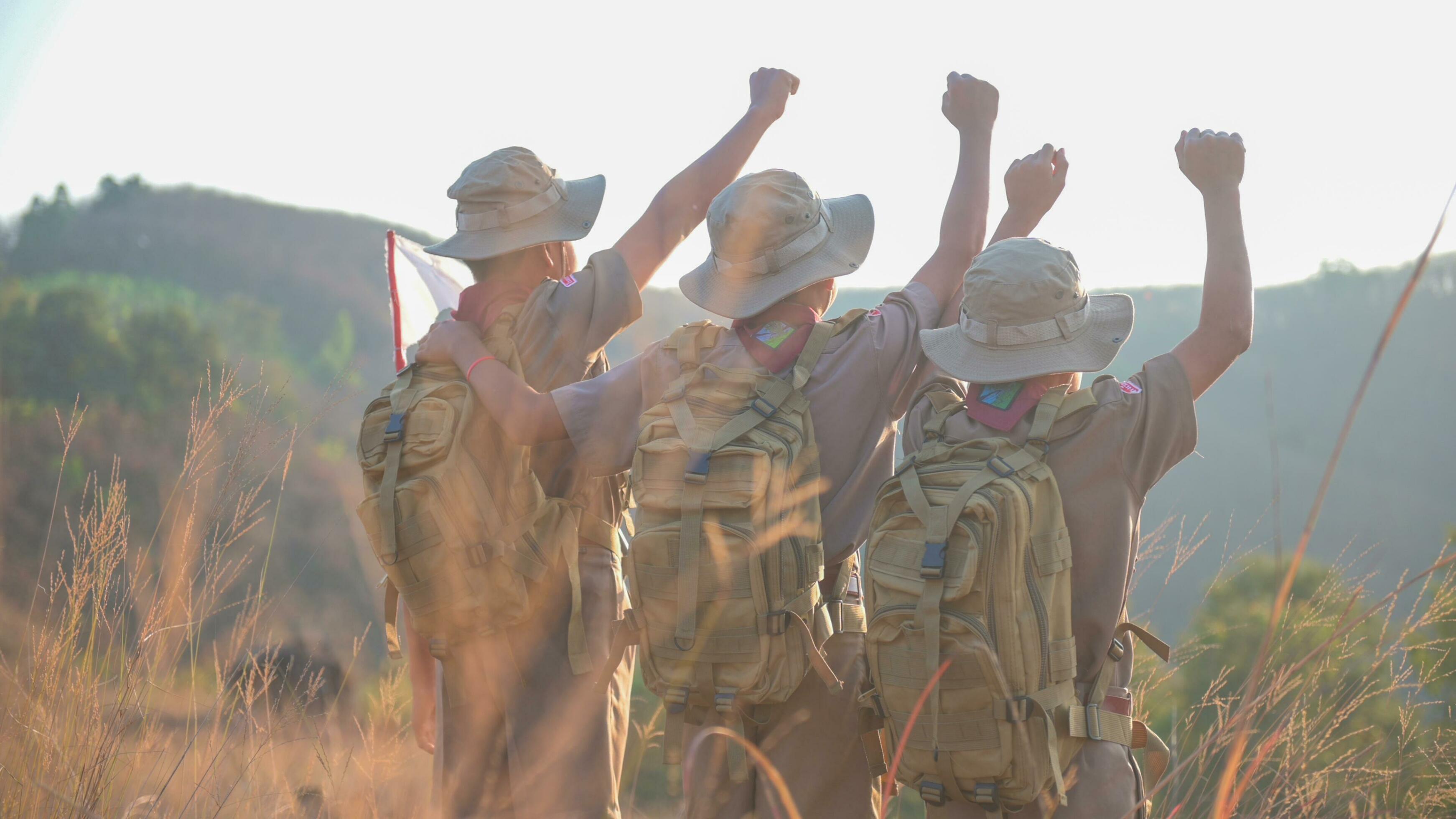 Boy Scouts team climbing with backpacks standing on mountain Boy Scouts rejoice at rock climbing ...