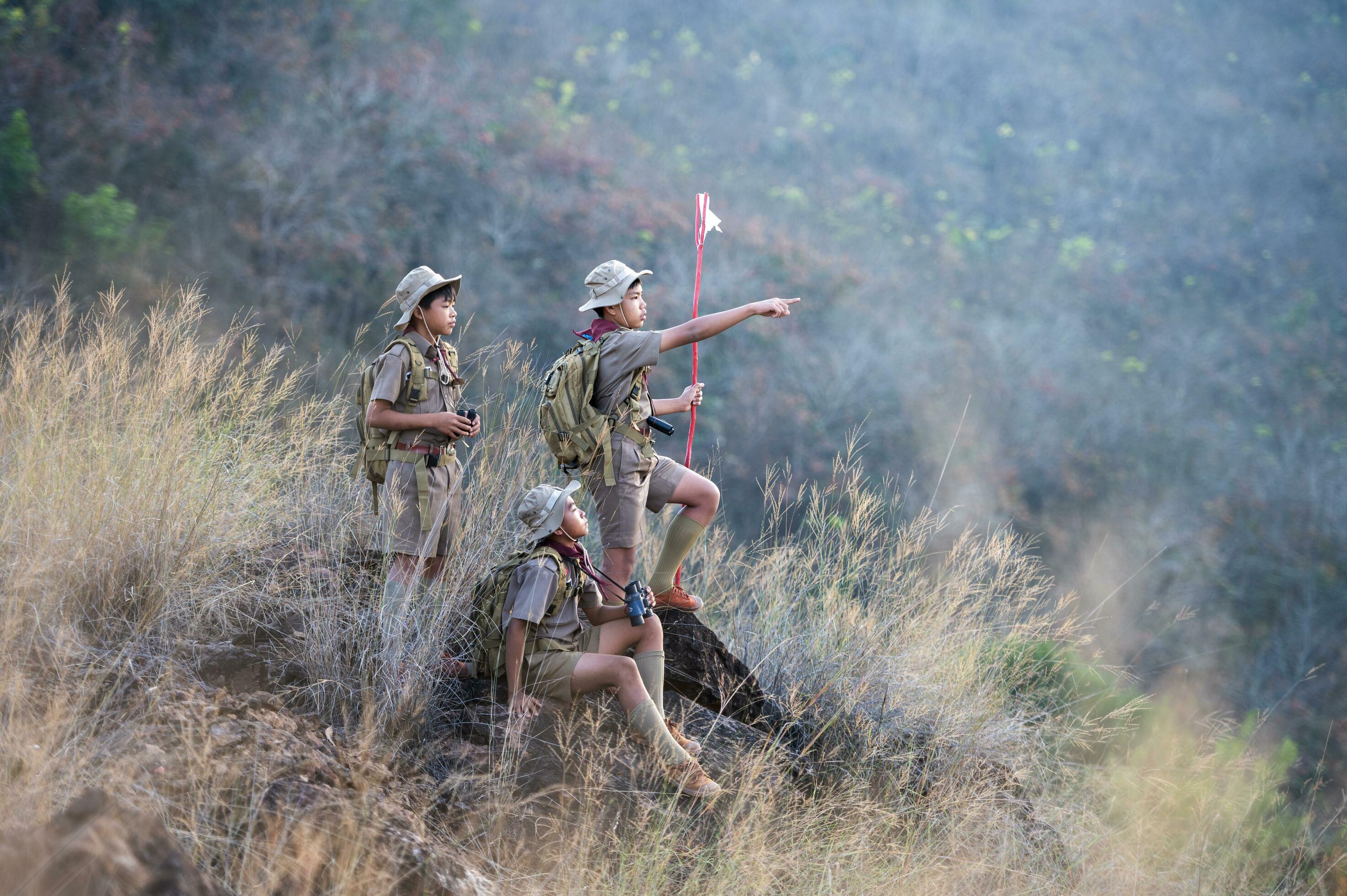 Boy Scouts team climbing with backpacks standing on mountain Boy Scouts rejoice at rock climbing ...