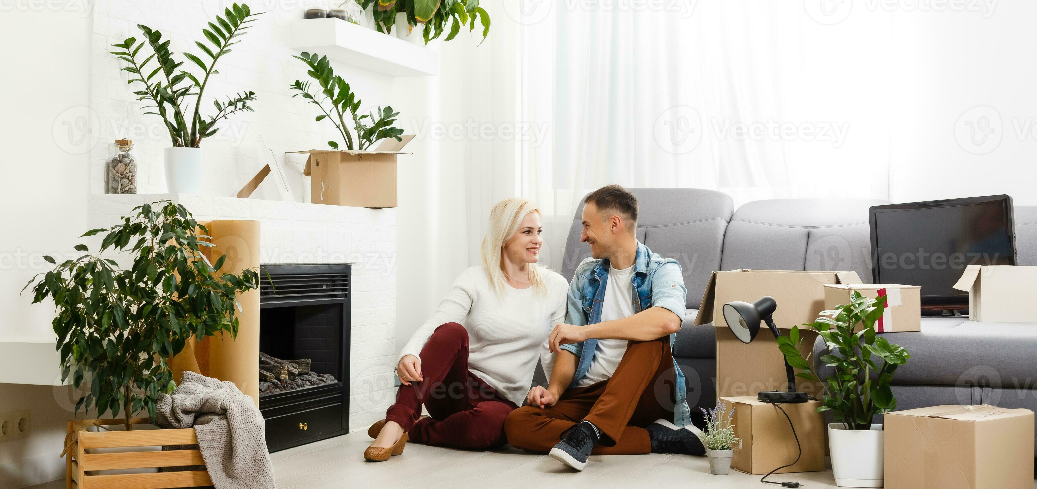 Young Couple Carrying Big Cardboard Box At New Home Moving House