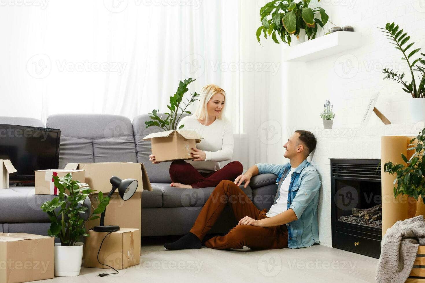 Young Couple Carrying Big Cardboard Box At New Home Moving House