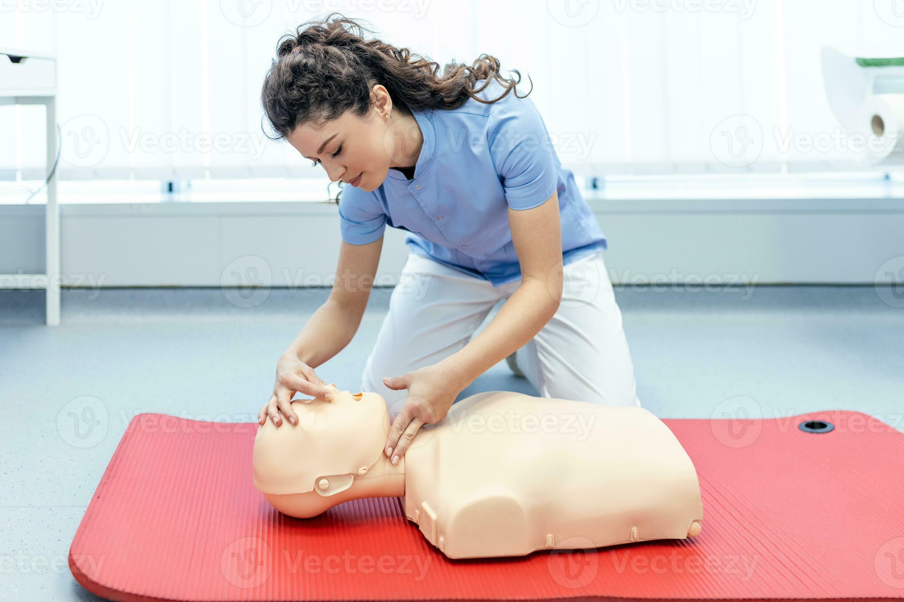 woman practicing cpr technique on dummy during first aid training. First Aid Training ...