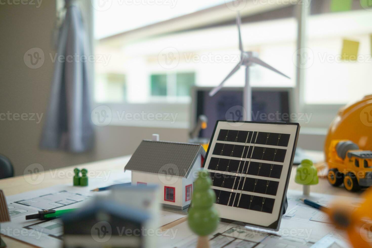 On desk of engineers lay model of house And solar panels to use in ...