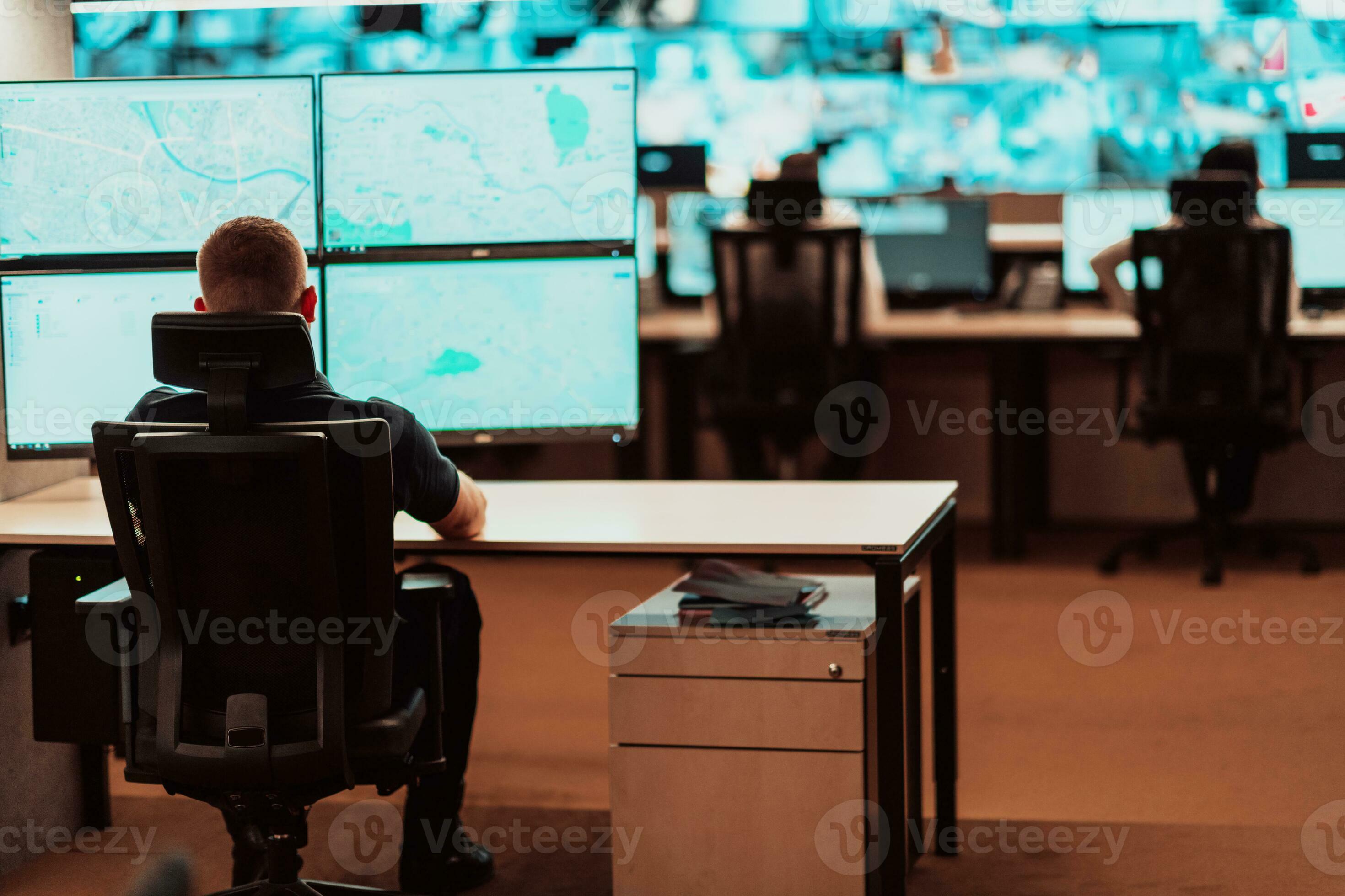 Male security operator working in a data system control room offices ...