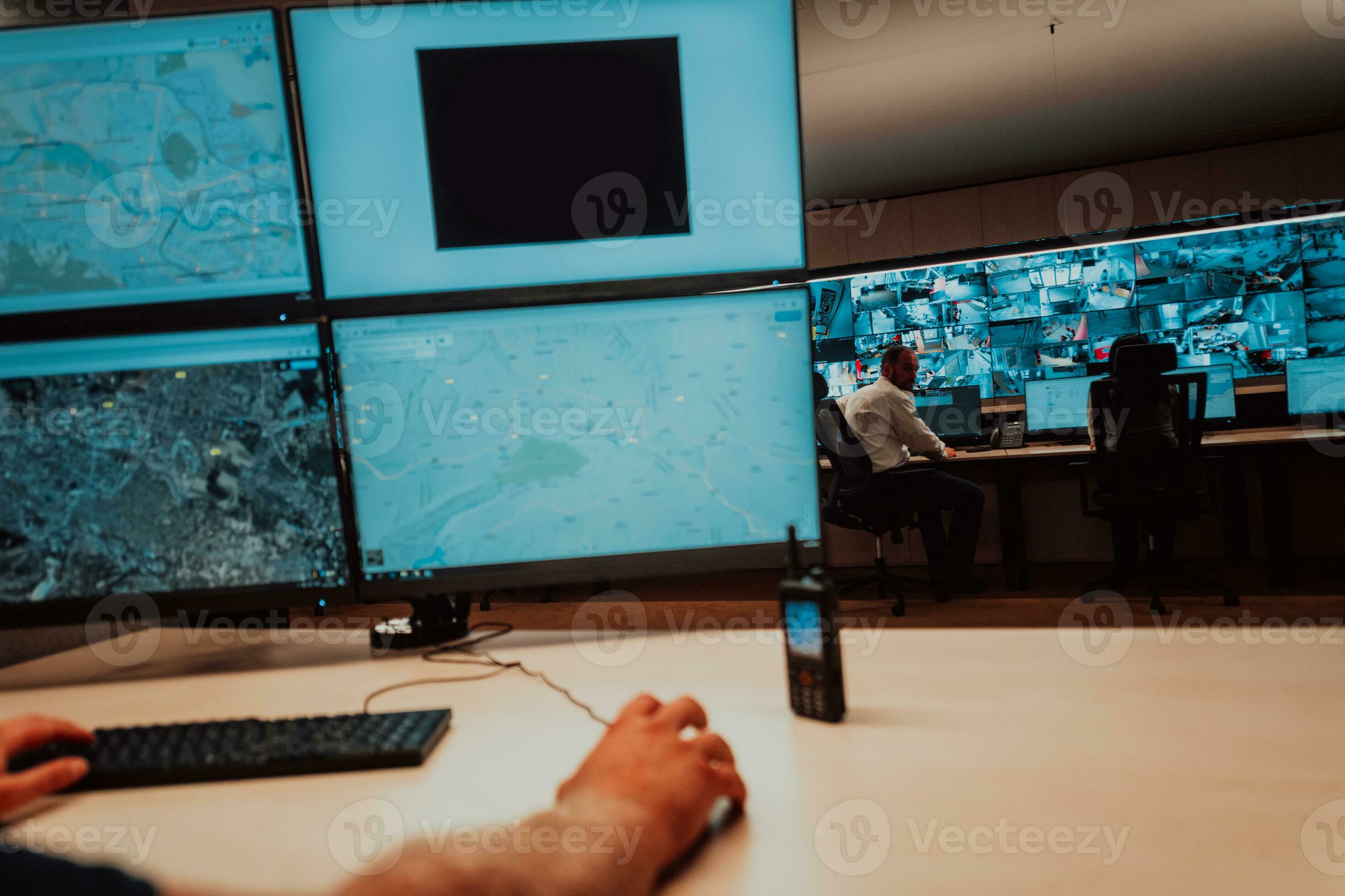 Male security operator working in a data system control room offices ...