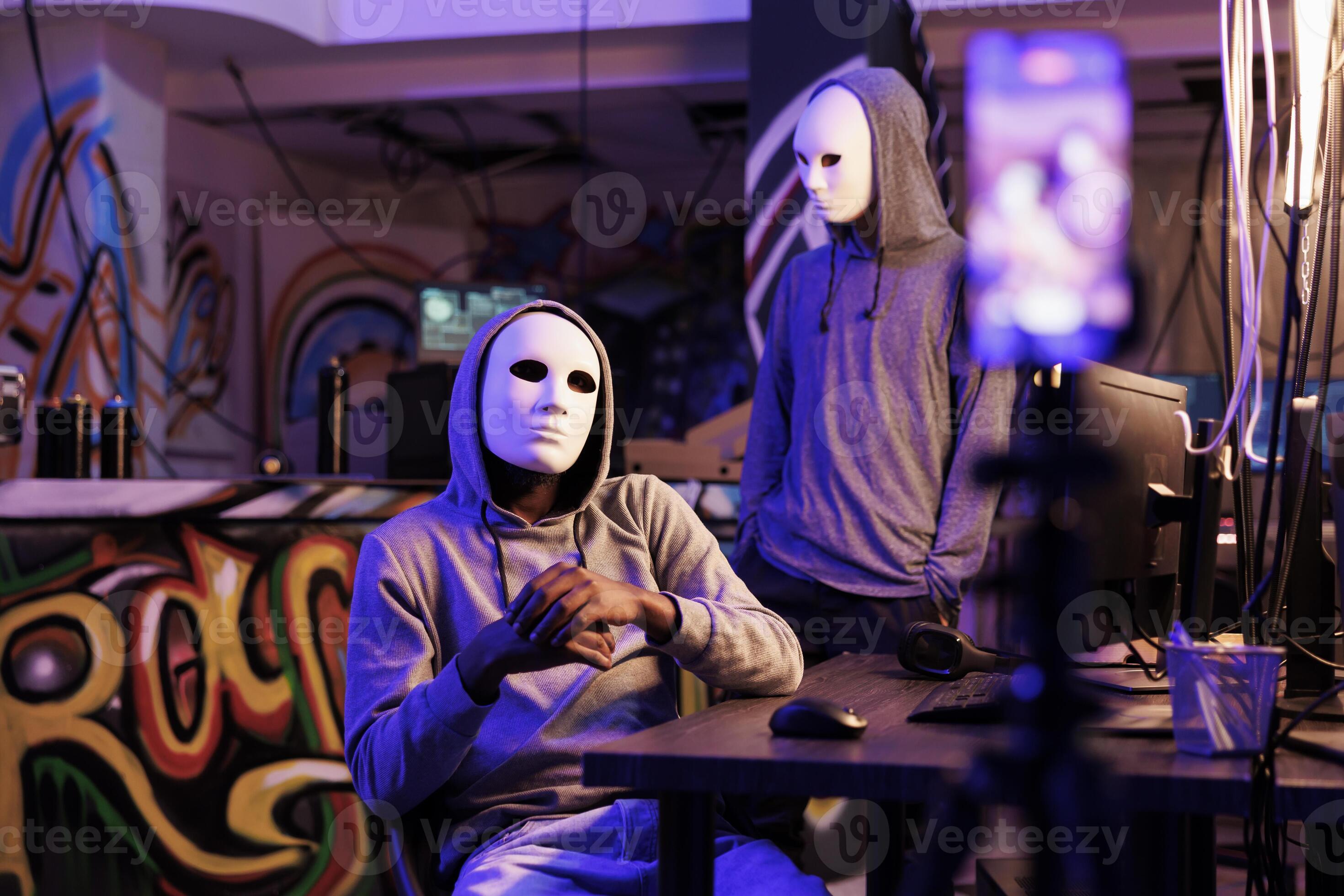 Scammers recording illegal activities on smartphone in abandoned warehouse. Anonymous internet ...