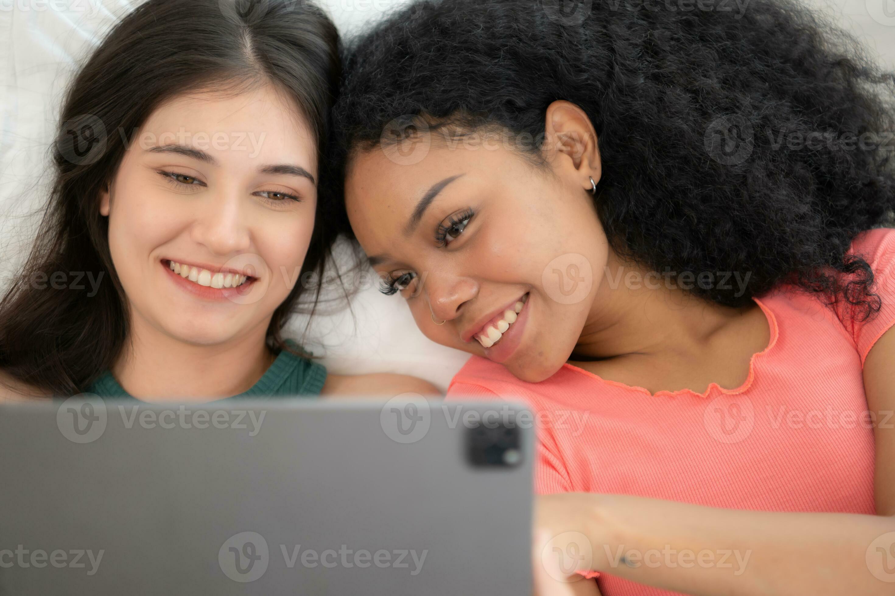 Happy Lesbian Couple Using Laptop On Bed At Home Young Multiethnic