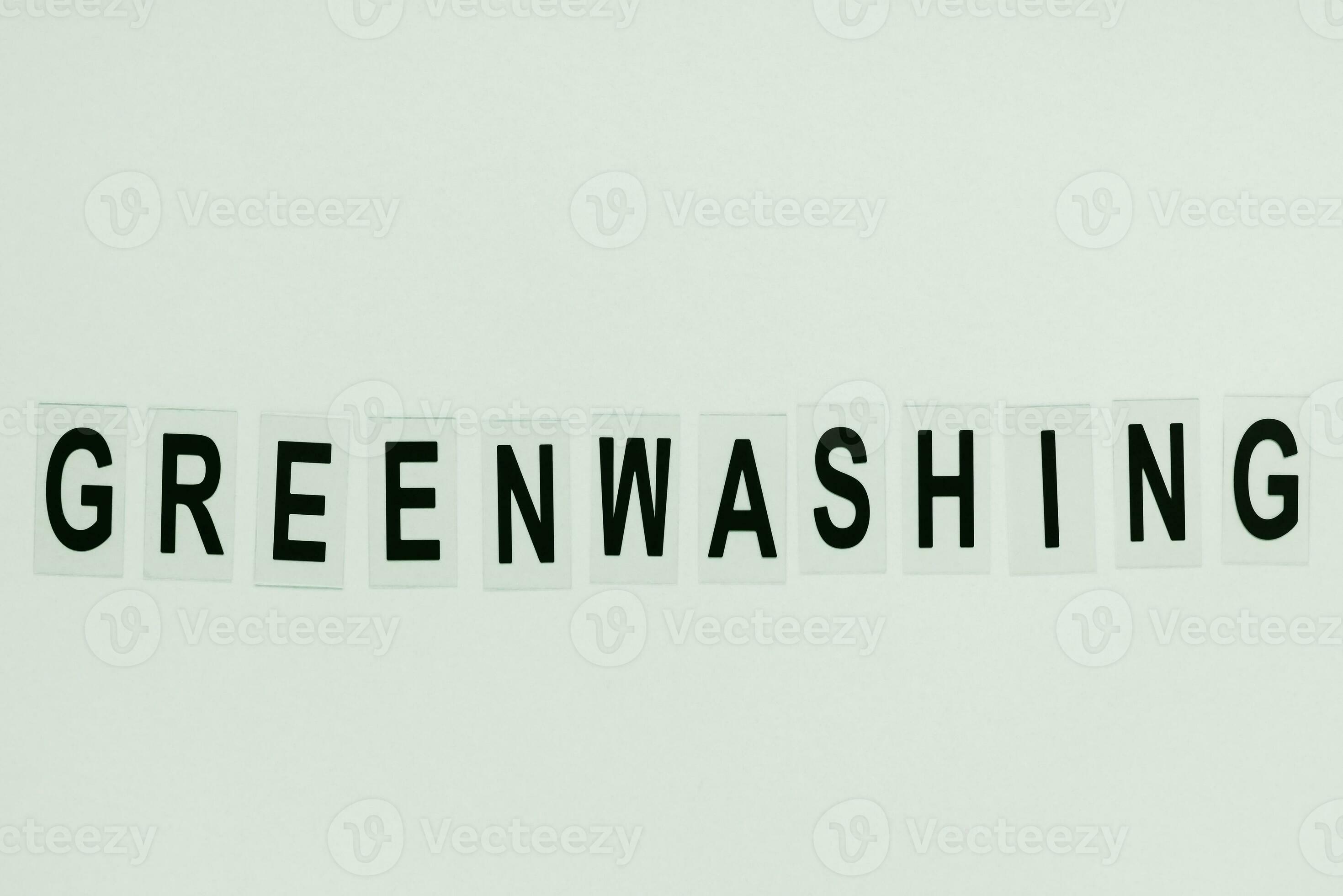 Text GREENWASHING on green background. Green PR, green marketing and misleading information ...