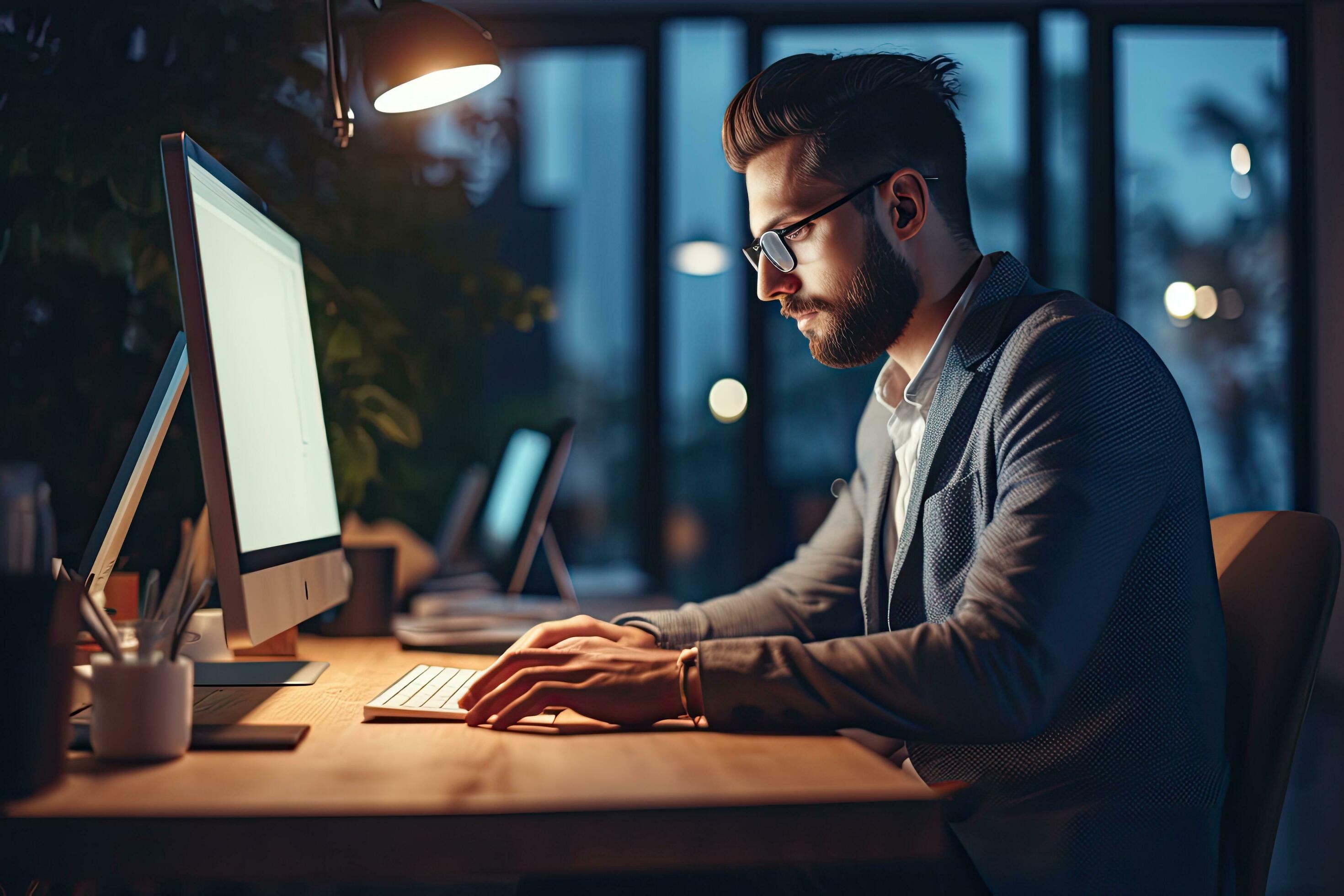 Portrait of a young businessman working on computer at night in office, Concentration ...
