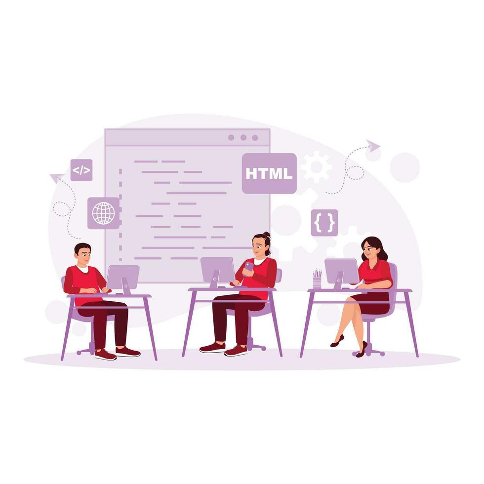 A group of young programmers sitting and working together on computers ...