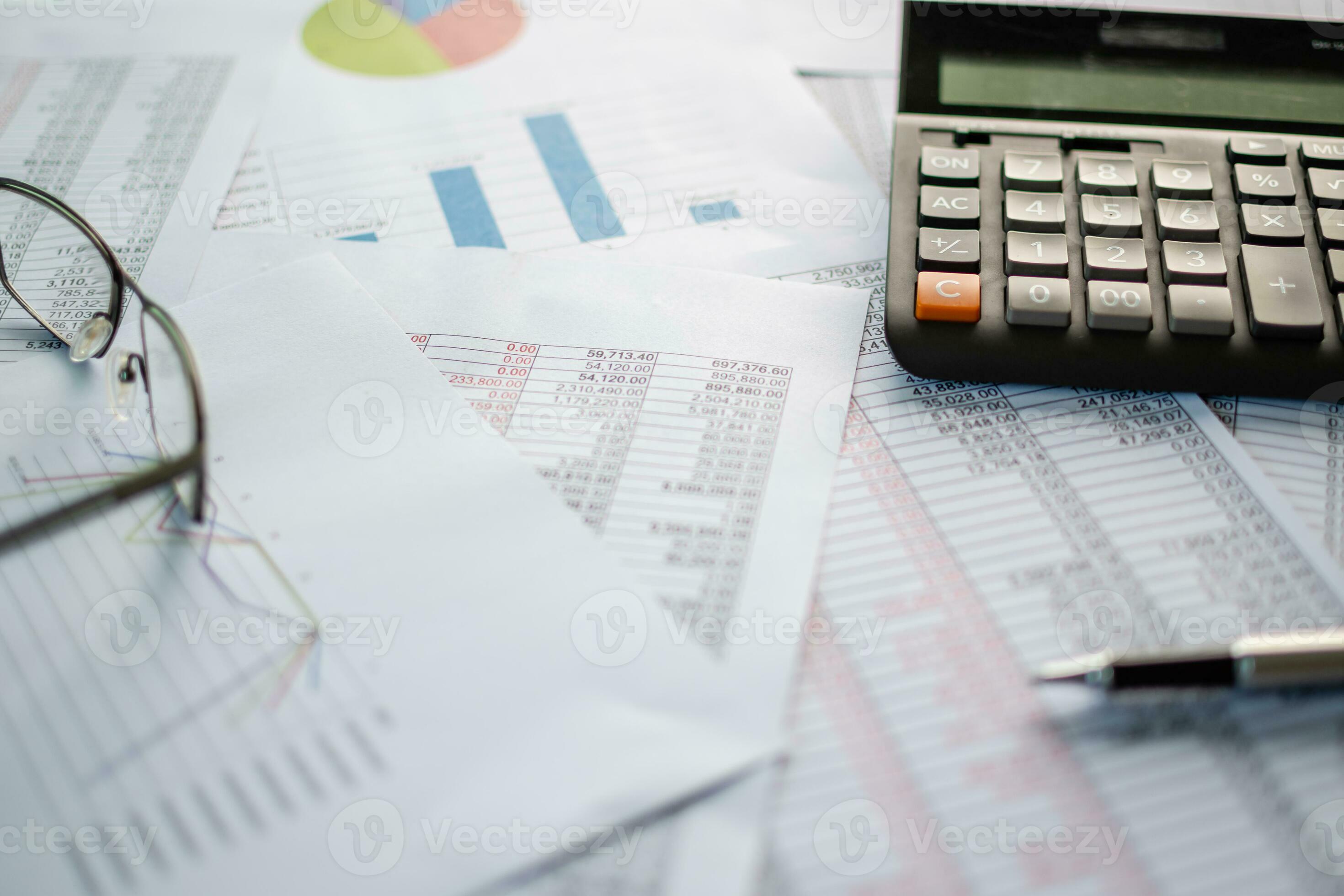 financial accounting work from home closeup calculator on desktop check account number on paper and calculator lots of numbers graph pen glasses on paper blurry background 32400243 Stock Photo at Vect...