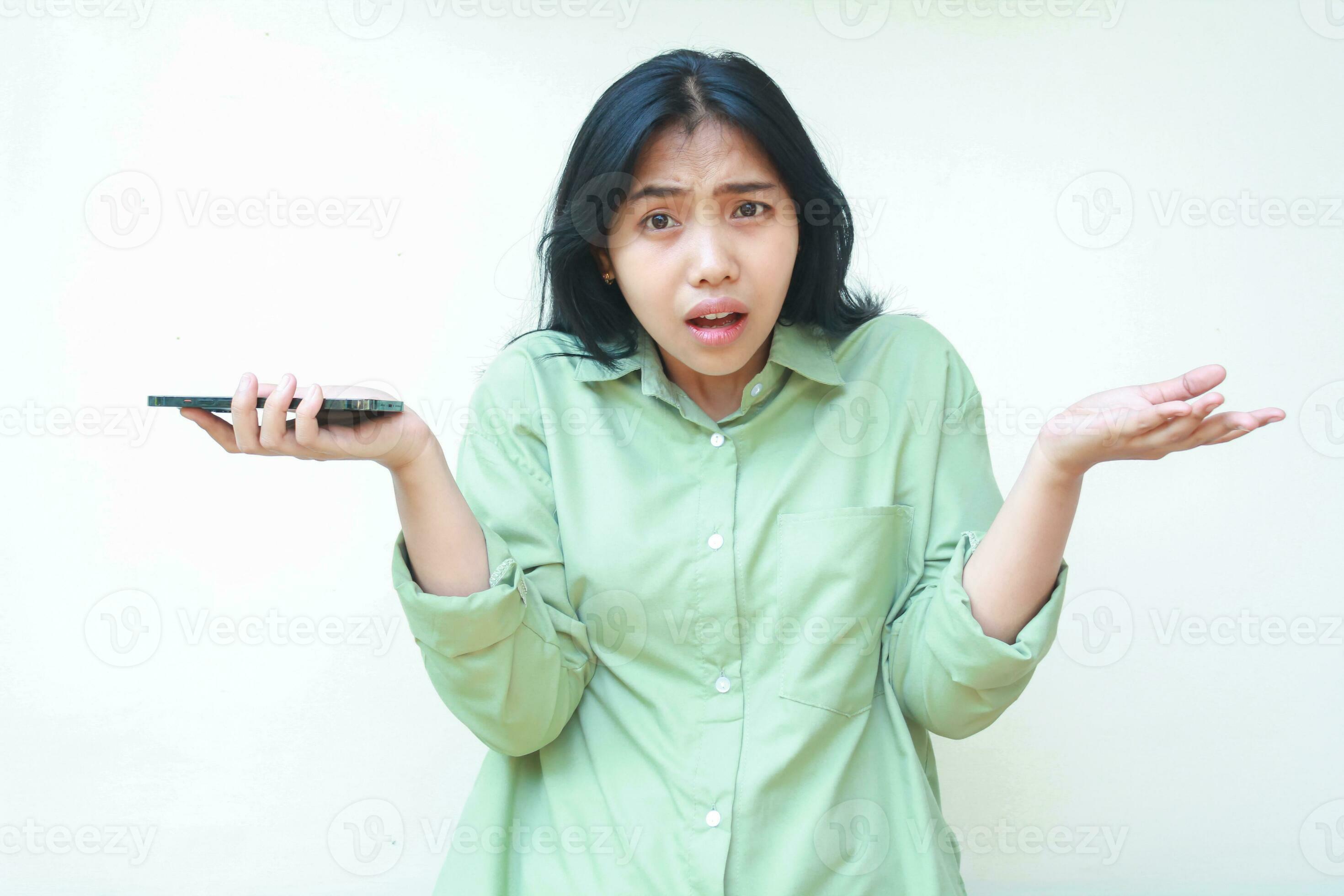 confused asian woman wearing green shirt shrug shoulders and spreads ...