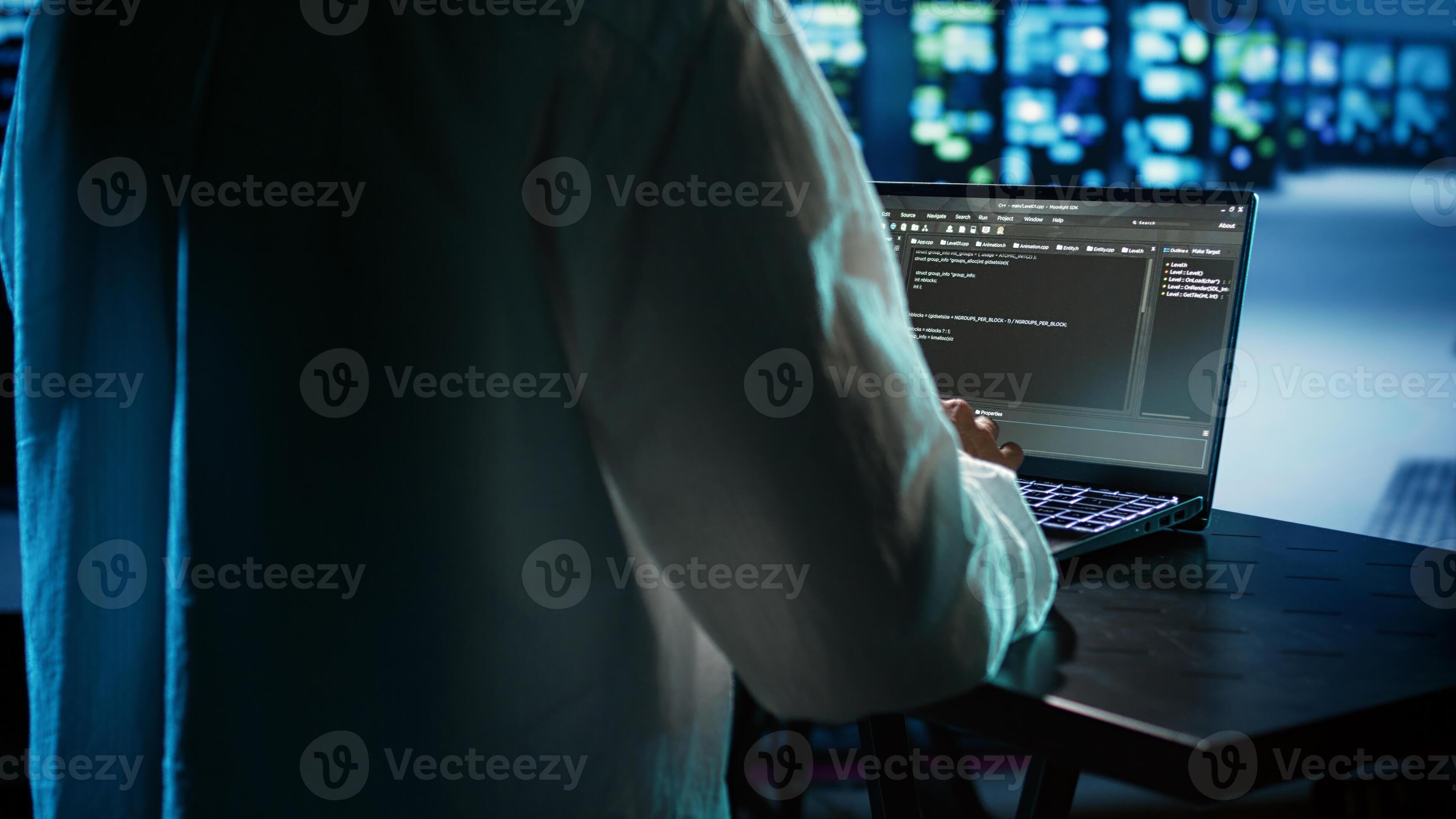 Licensed programmer running code on laptop, troubleshooting and updating data center equipment ...