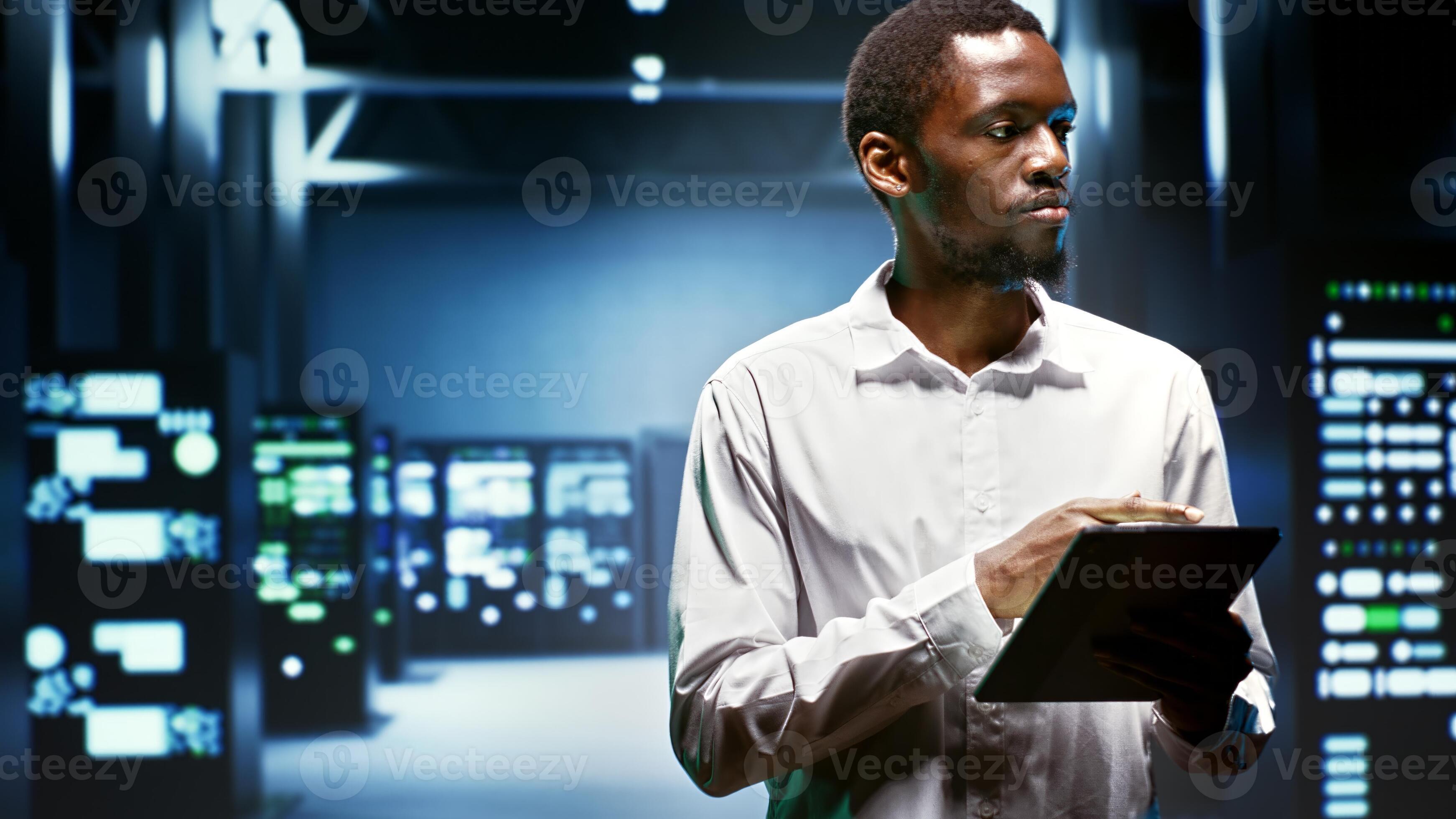 Cheerful electrician inspecting server hub providing vast computing resources and storage ...