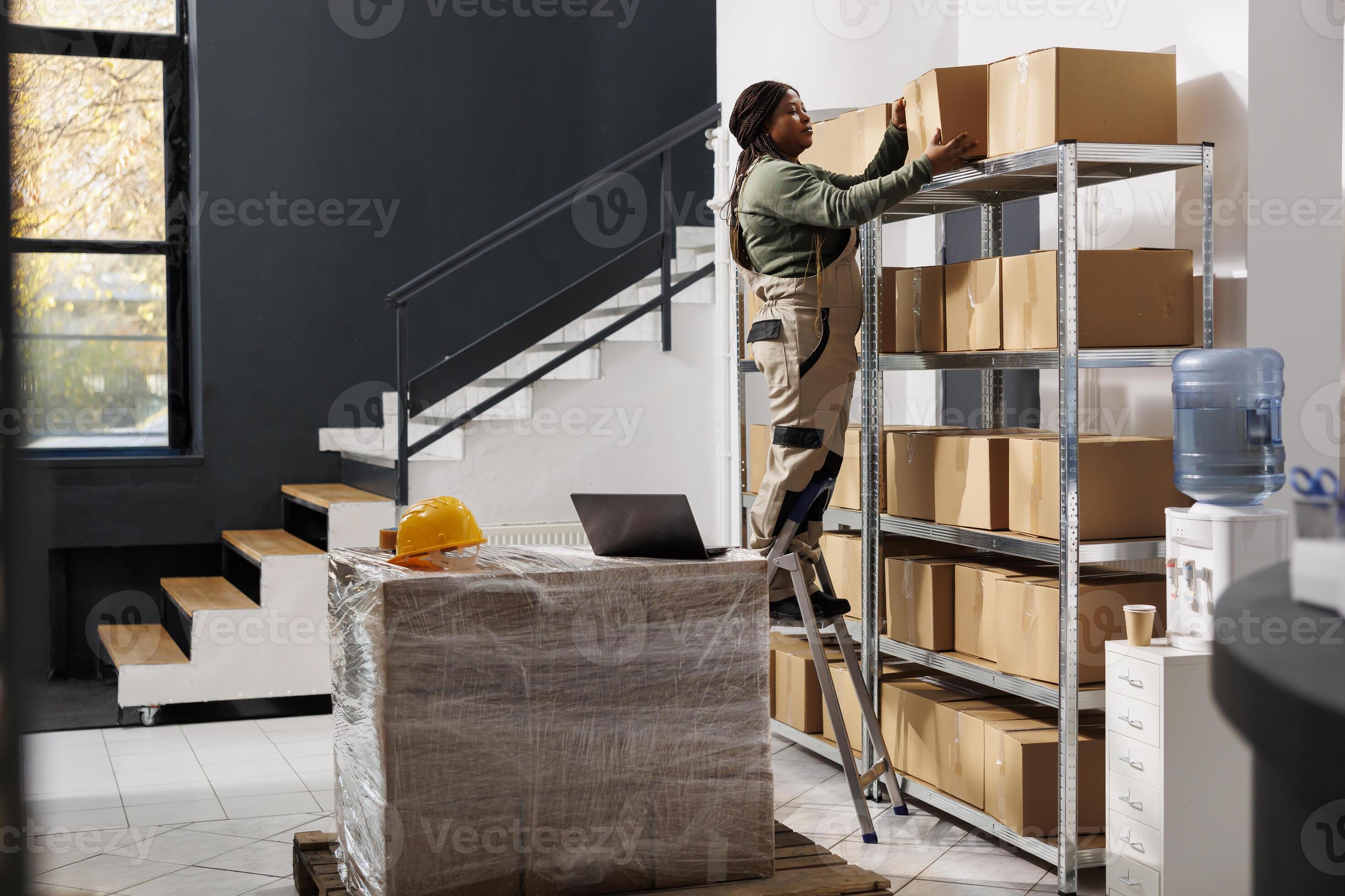 almacén empleado mirando a metálico estante tomando fuera cartulina caja durante almacén ...
