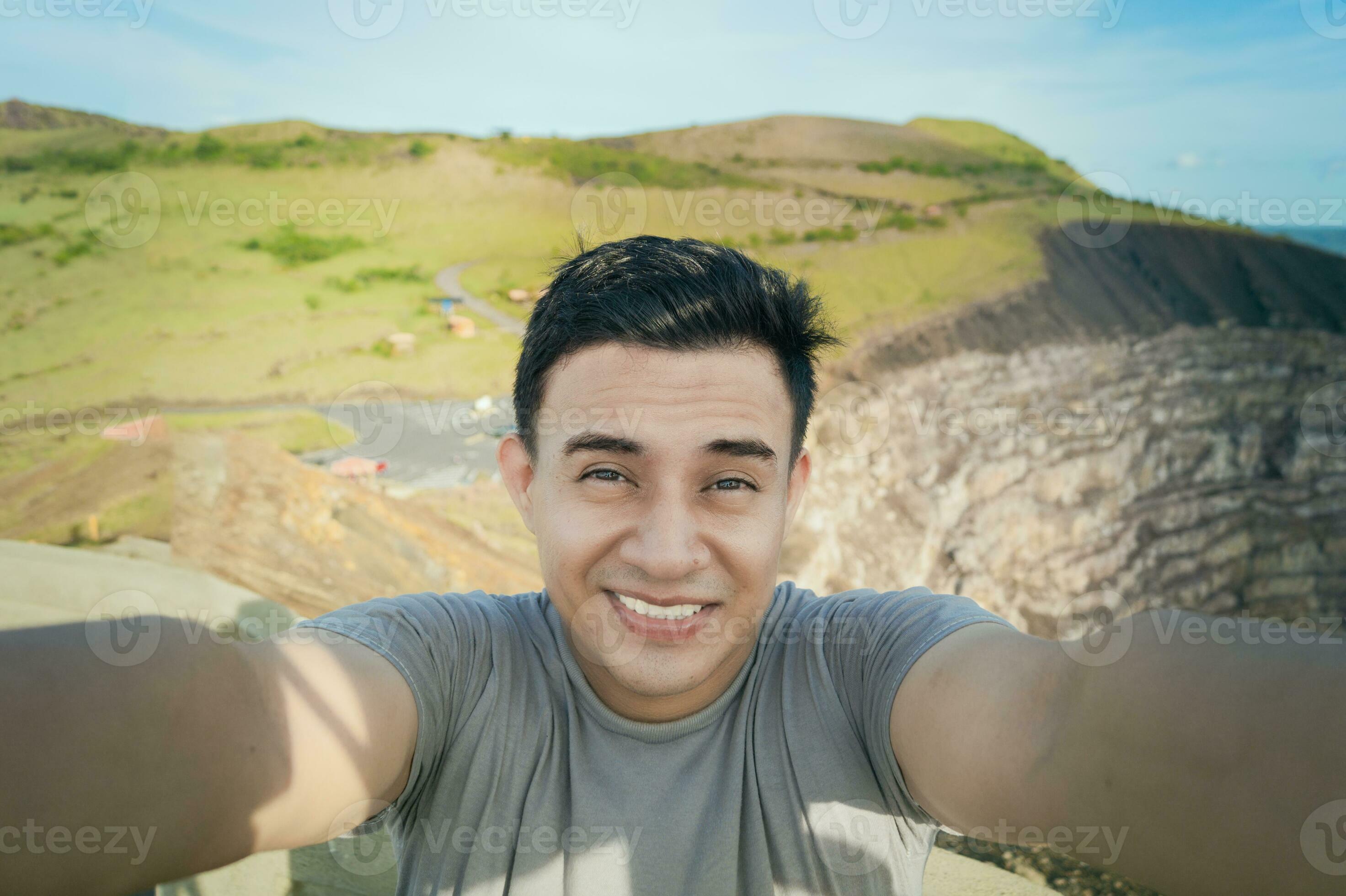 Adventurous man taking a selfie at a viewpoint. Close up of person ...