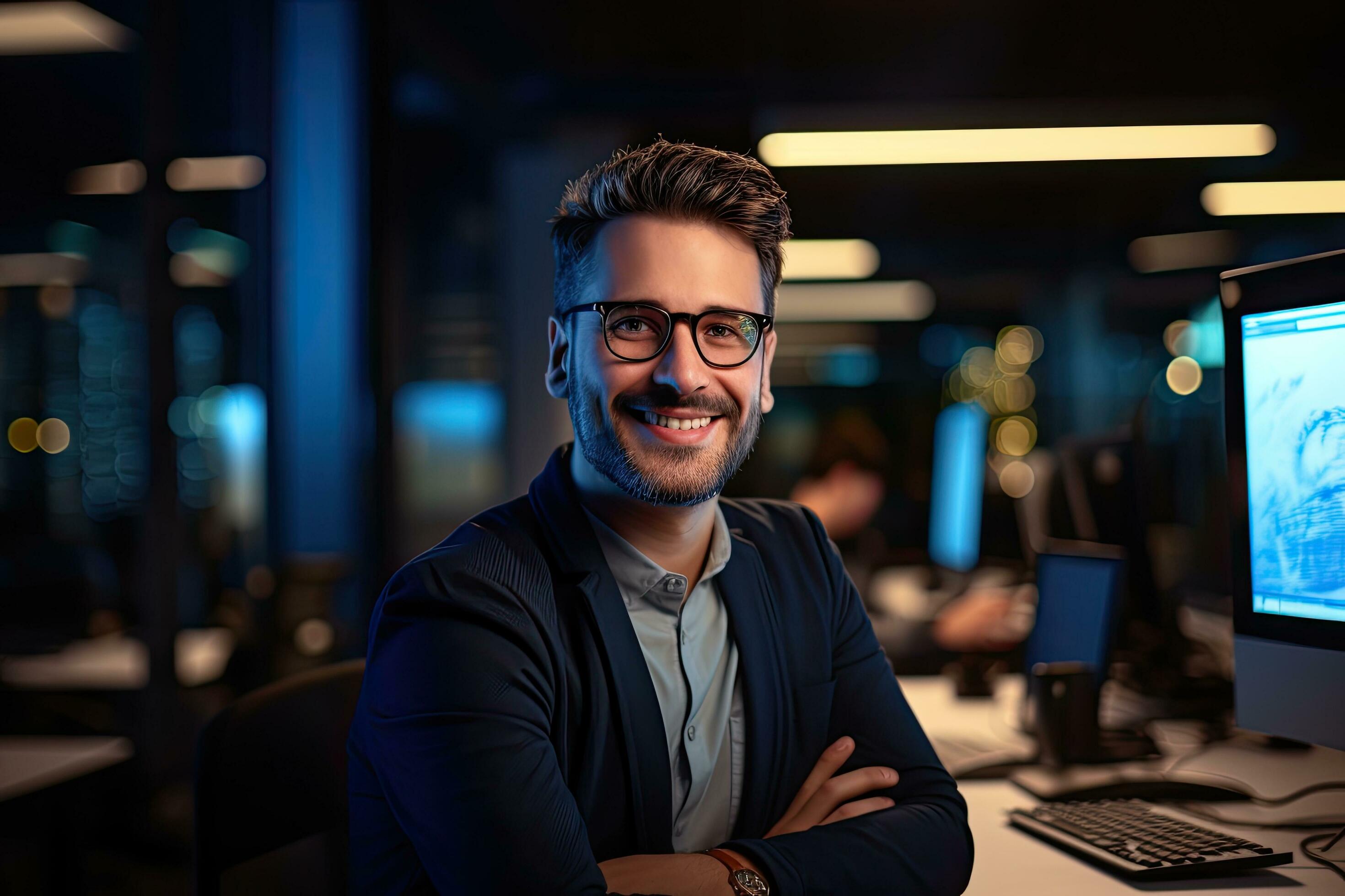 Portrait of a handsome young businessman wearing glasses and smiling while working in the night ...