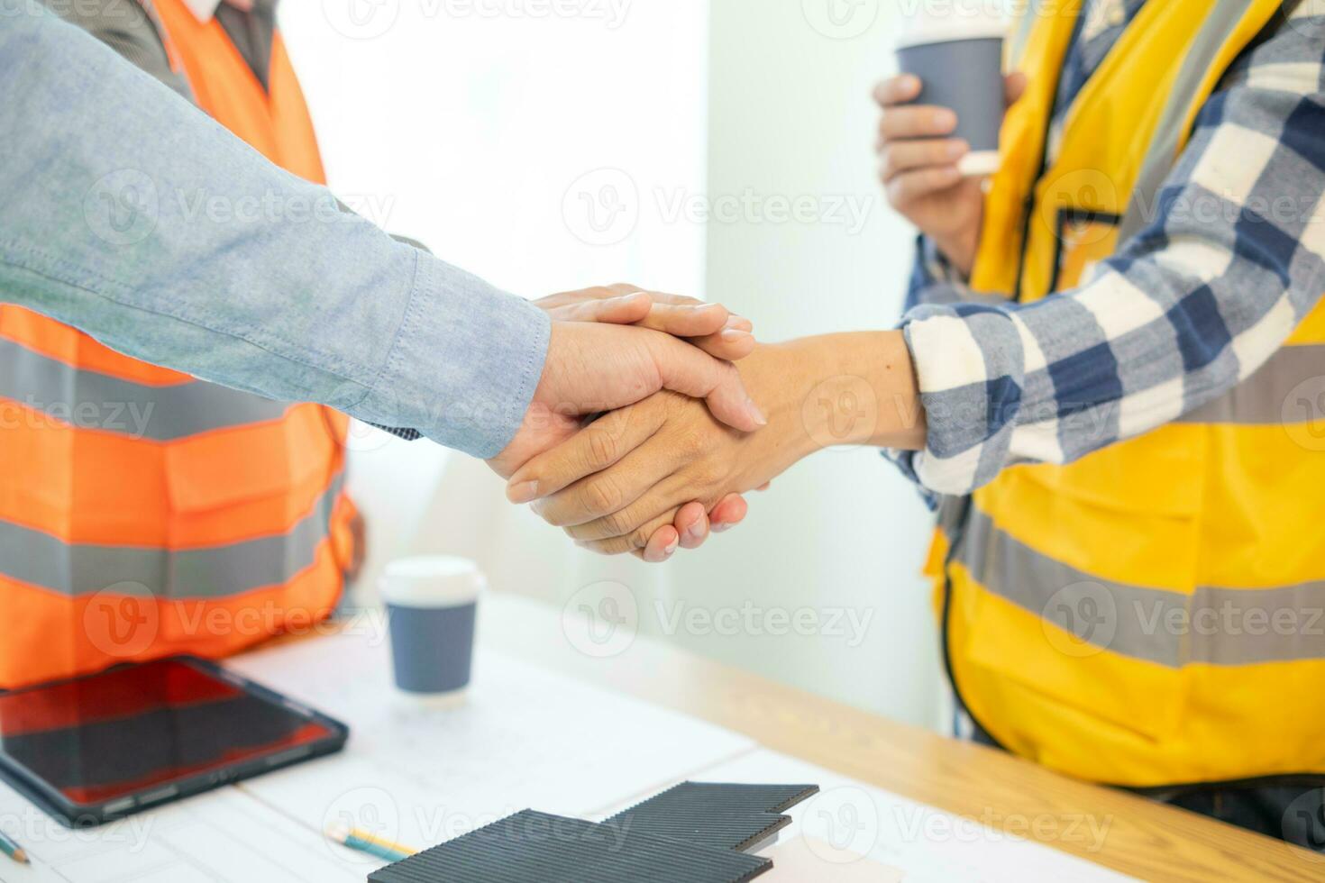 Architects and construction engineering handshake after meeting discuss structural blueprints ...