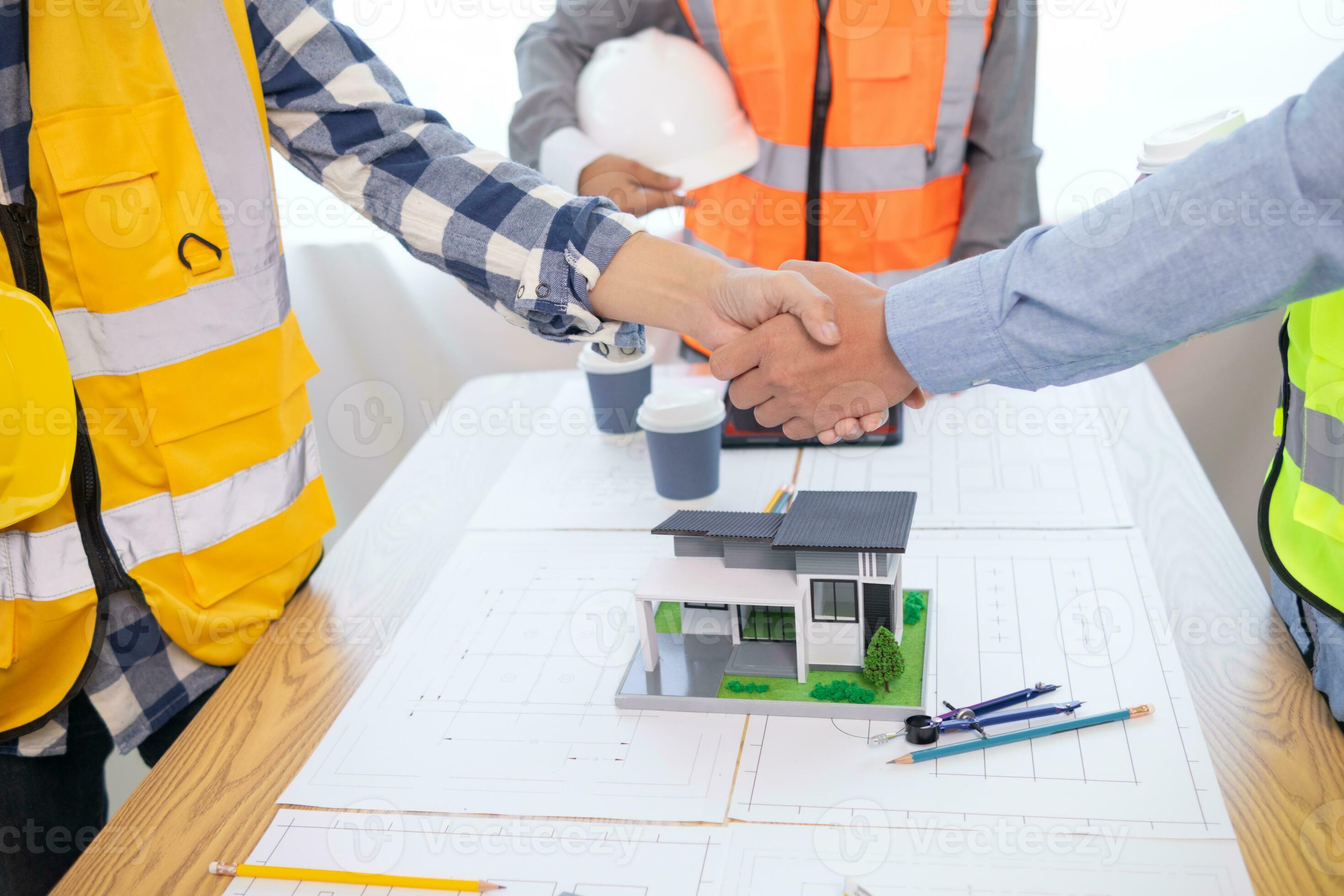 Architects and construction engineering handshake after meeting discuss structural blueprints ...