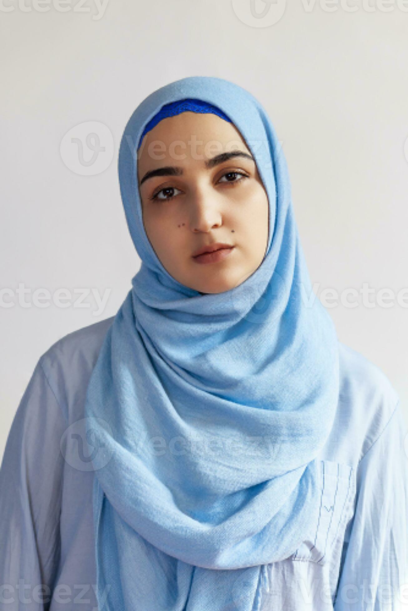 Beautiful Muslim woman in hijab against white background. Portrait of pretty middle-eastern ...