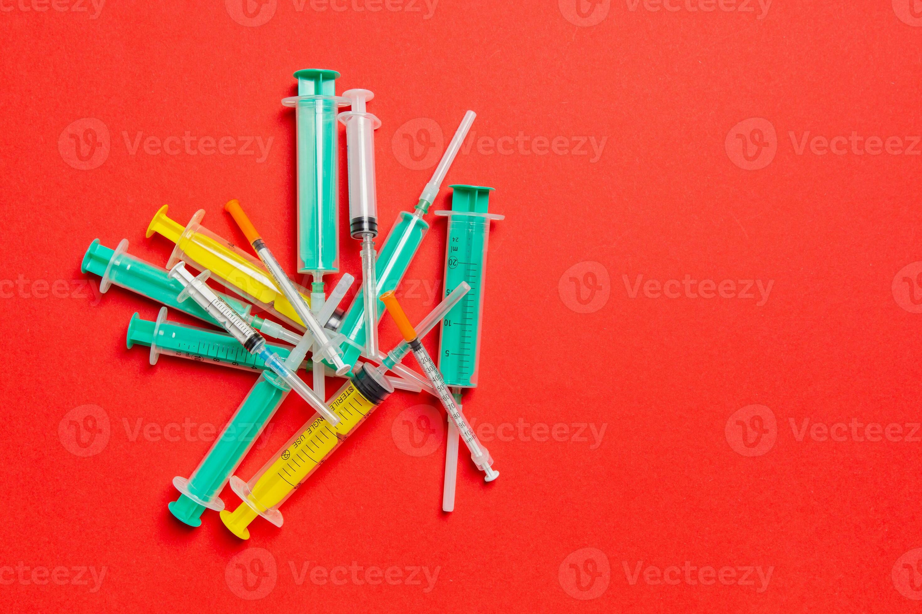 Top View Of A Heap Of Syringes And Insulin Syringes At Red Background Medical Injection Concept