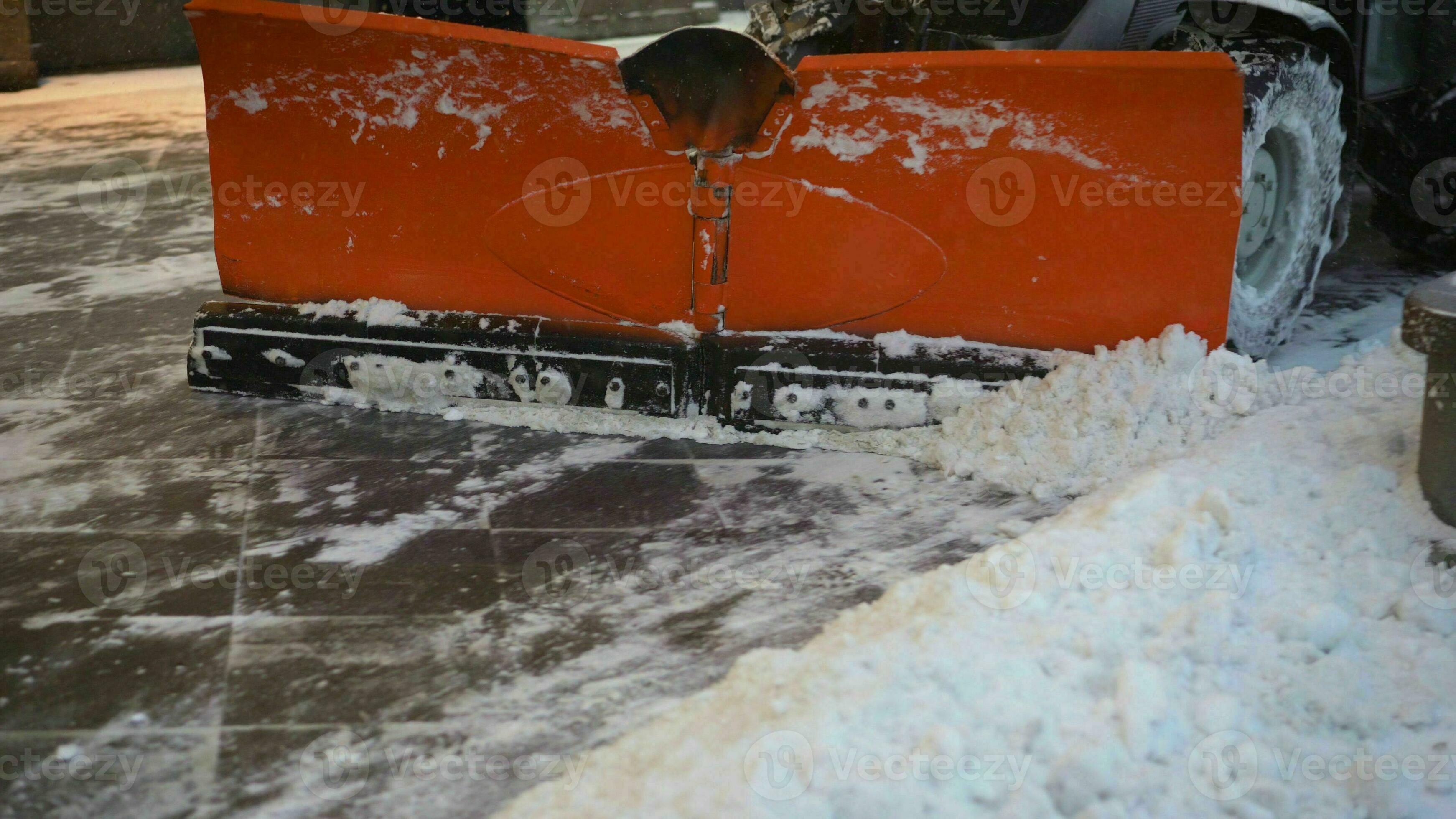 The tractor cleans the pavement in winter. Tractor cleaning the road ... The tractor cleans the pavement in winter. Tractor cleaning the road ...