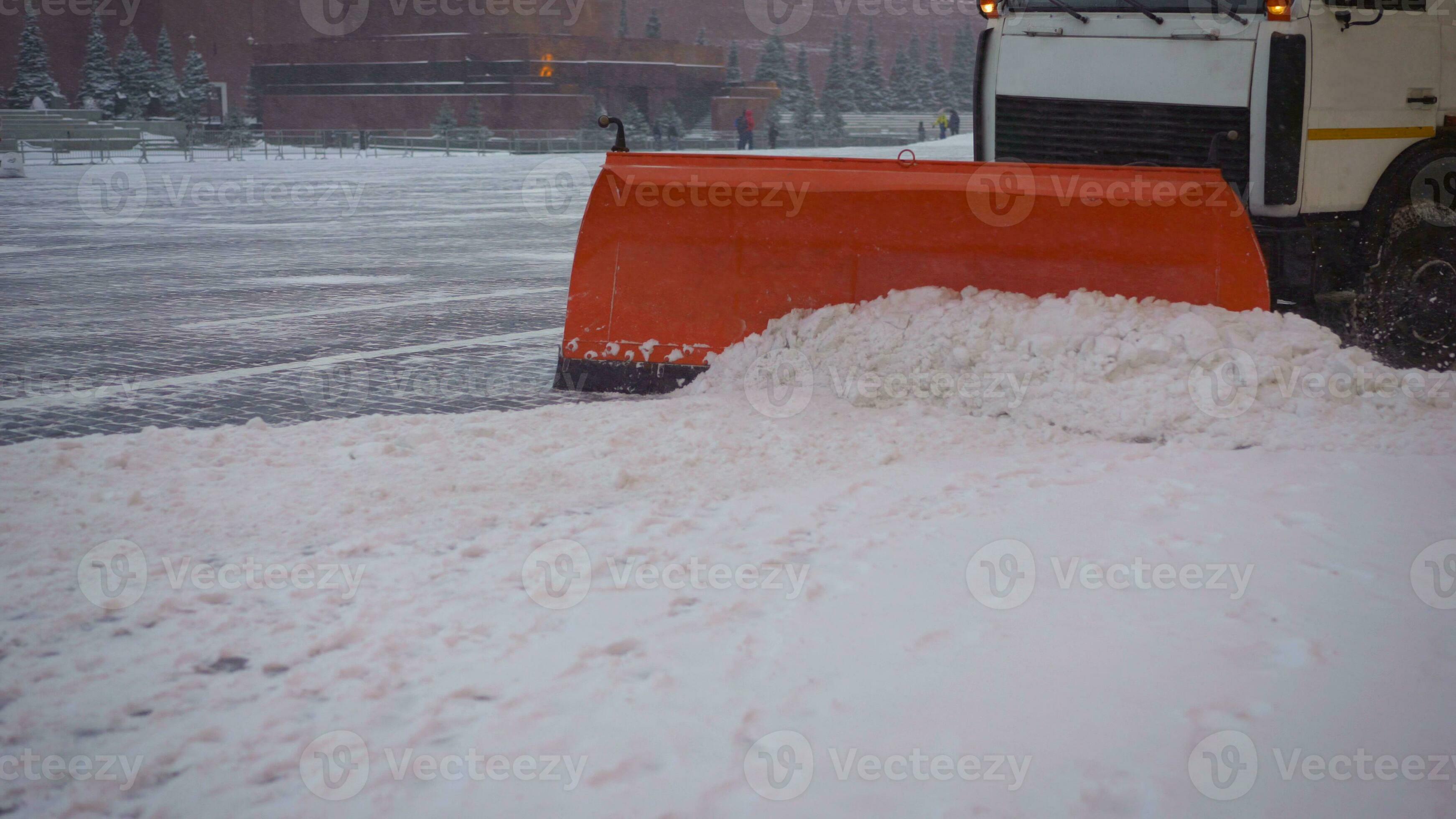 The tractor cleans the pavement in winter. Tractor cleaning the road ... The tractor cleans the pavement in winter. Tractor cleaning the road ...