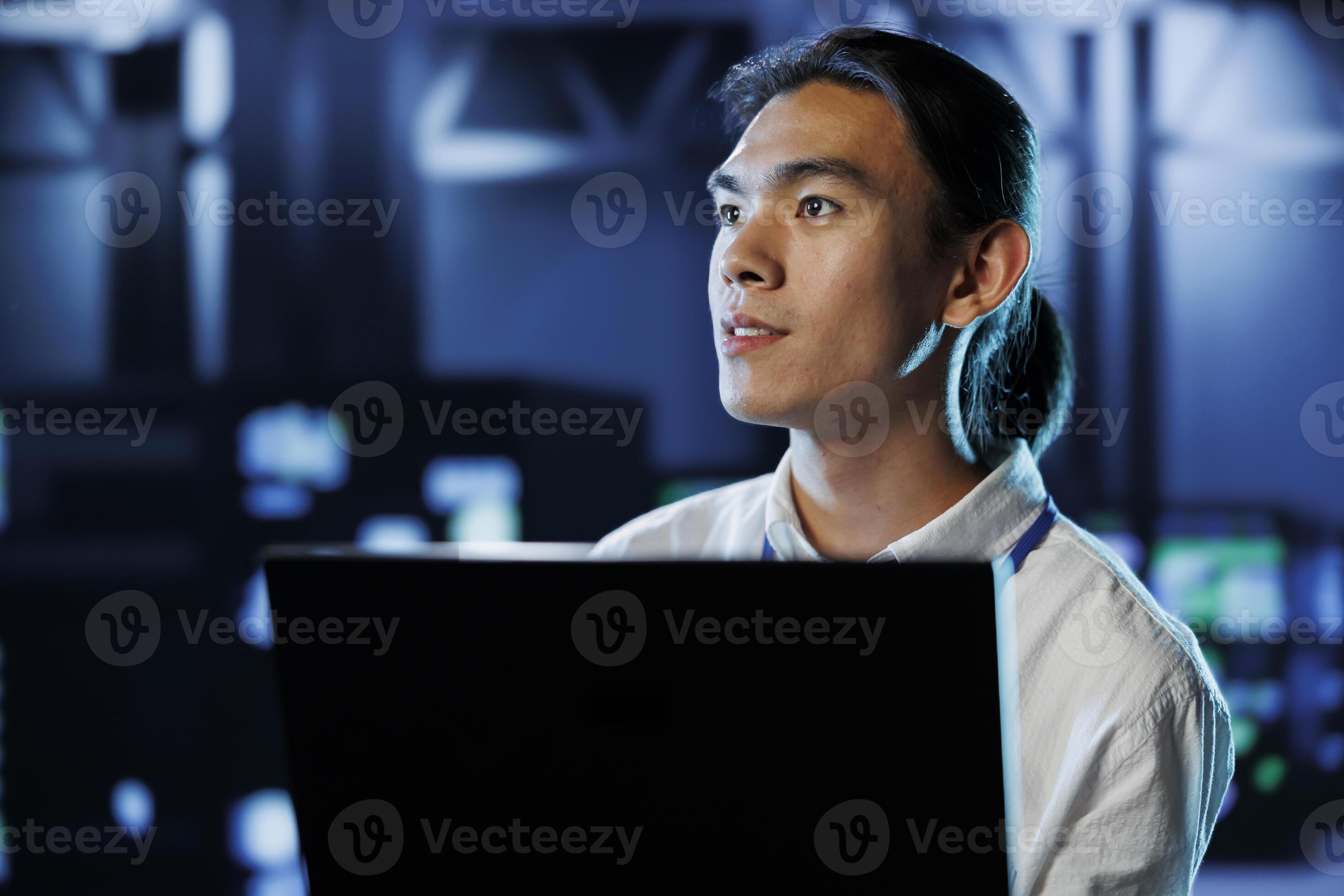 Licensed technician between server hub rows providing processing resources for businesses ...