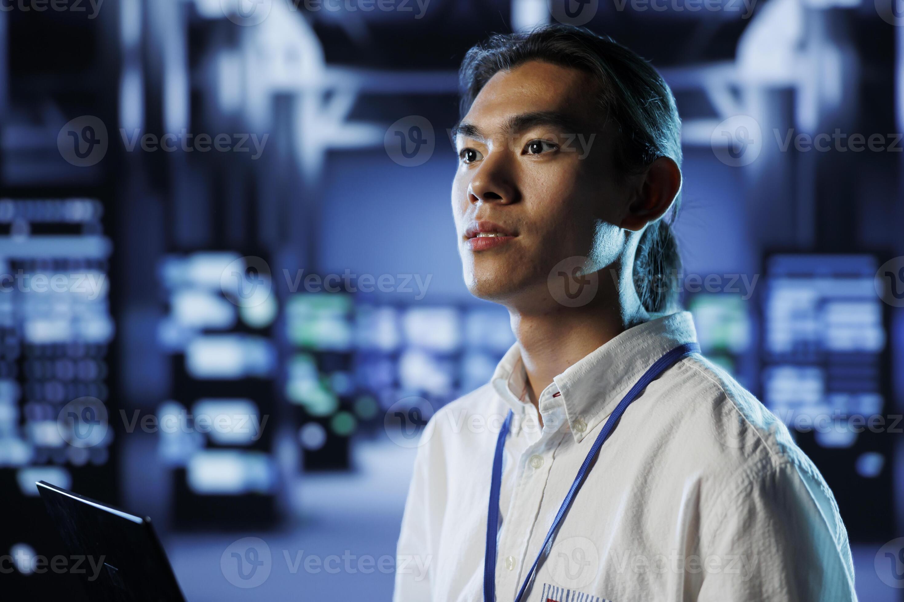 Certified technician in data center uses laptop to prevent system overload during peak traffic ...