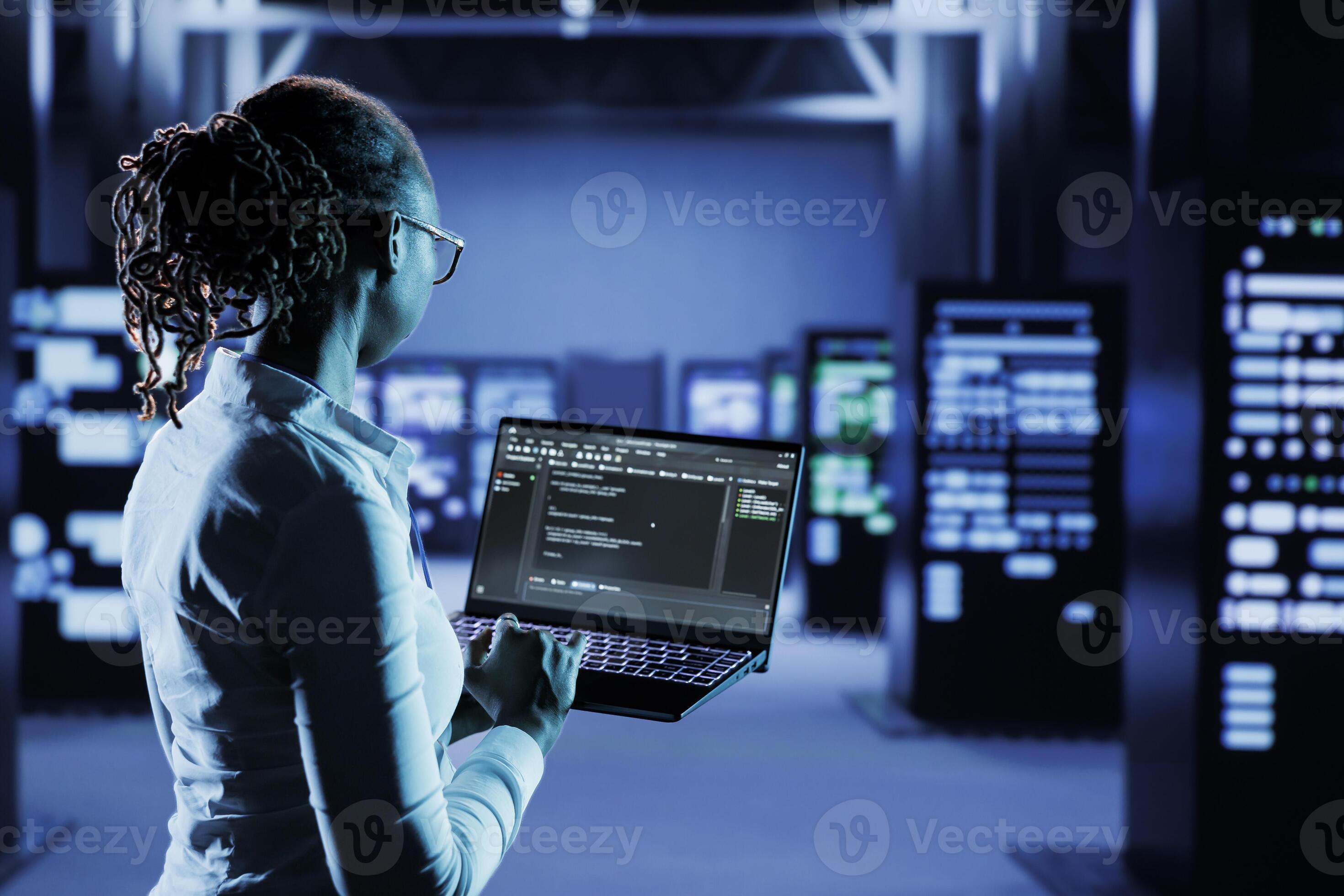 Experienced specialist running code and programming on laptop, troubleshooting and upgrading ...