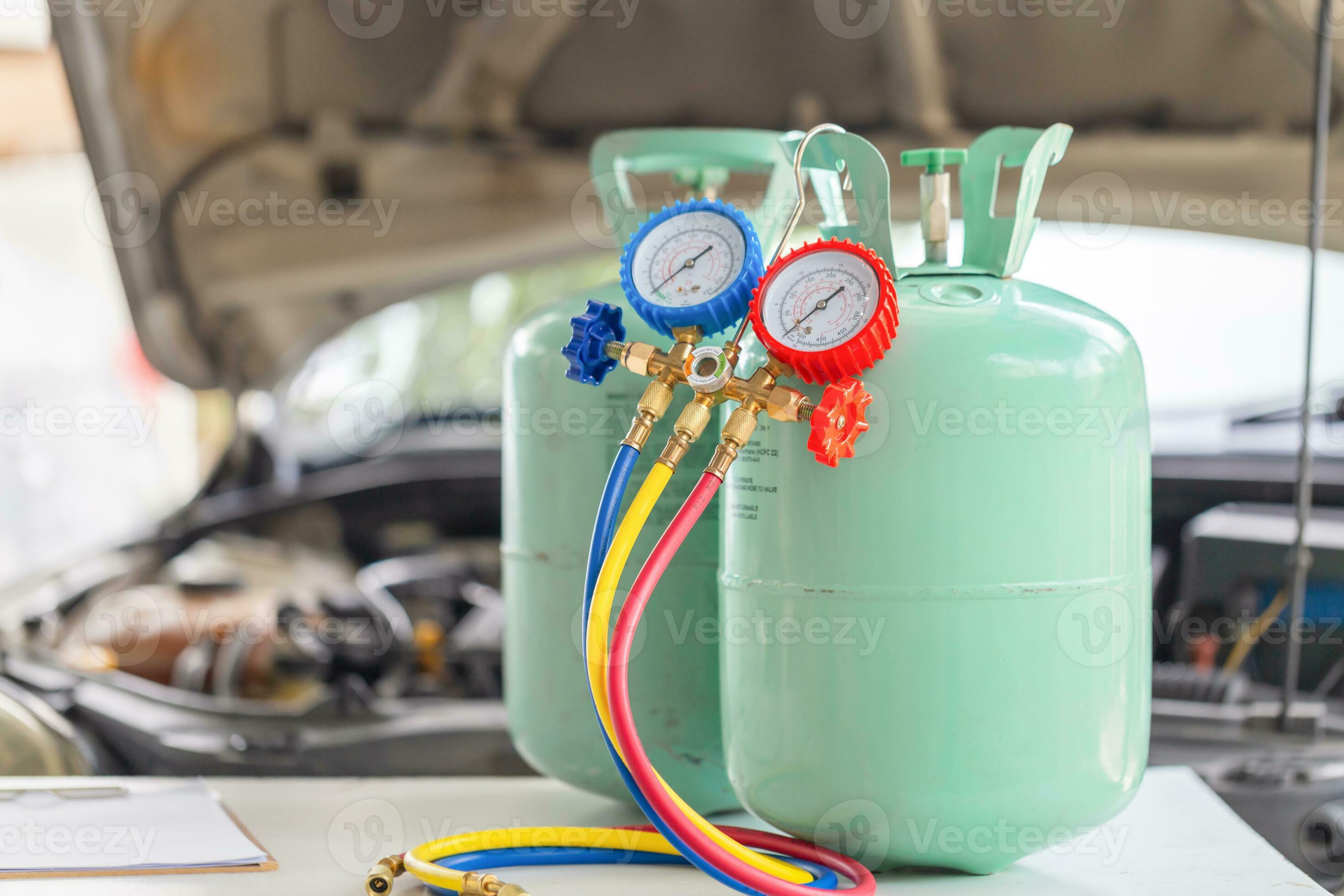 Manifold tool gauge bucket refrigerant applies to car air conditioning with blurred technician ...
