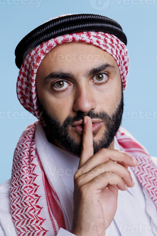 Man Wearing Muslim Headscarf Signaling For Silence With Hushed Finger To Lips Closeup Portrait