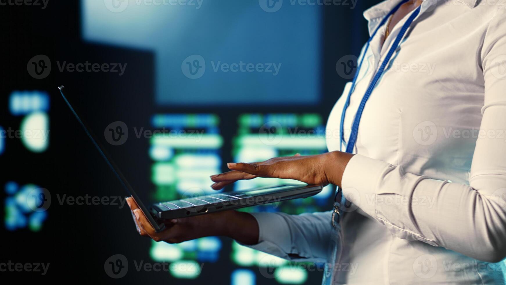 System administrator programming in server farm housing advanced equipment storing massive ...