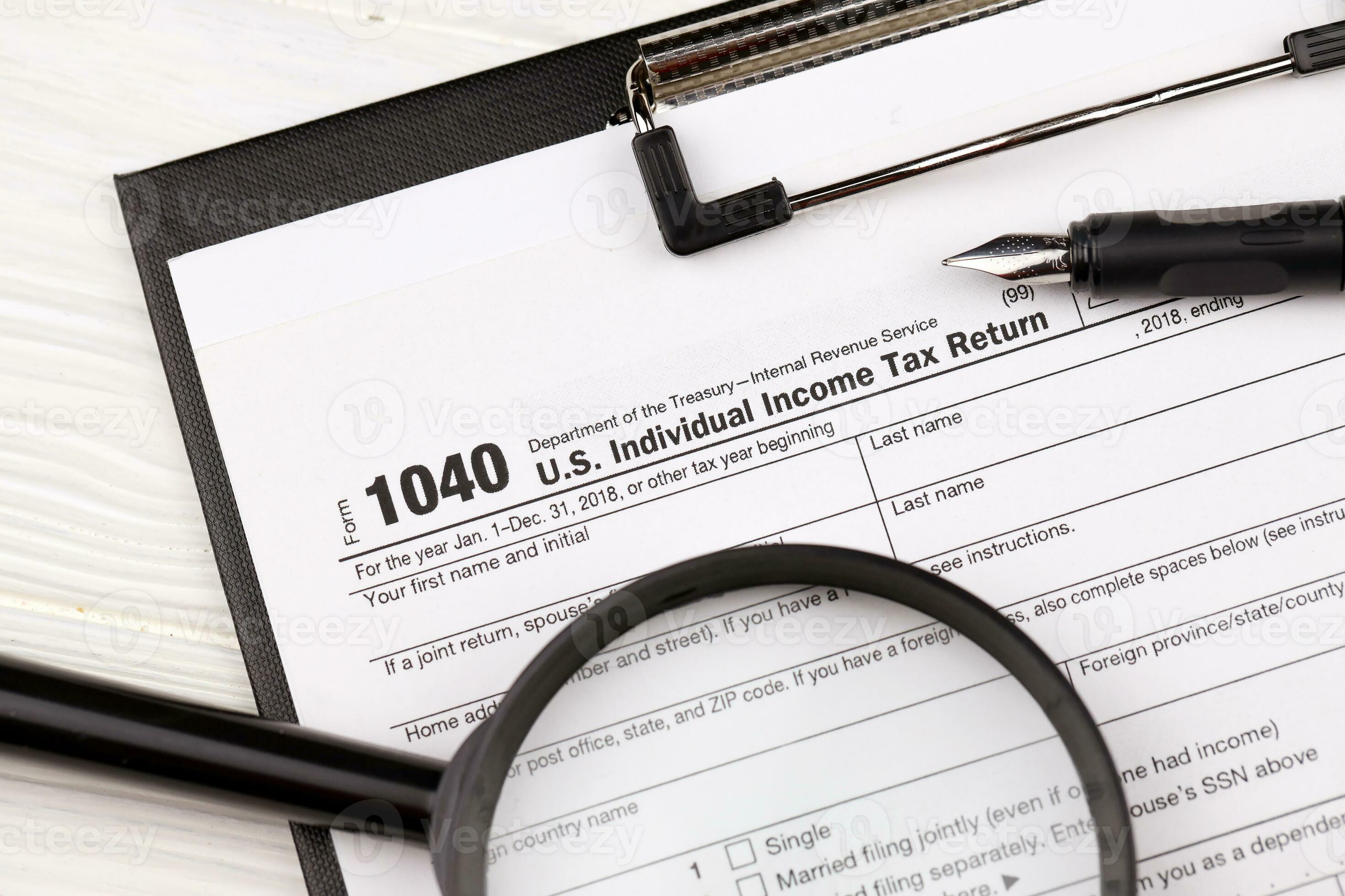 Form 1040 US Individual Income Tax Return on A4 tablet lies on office table with pen and ...