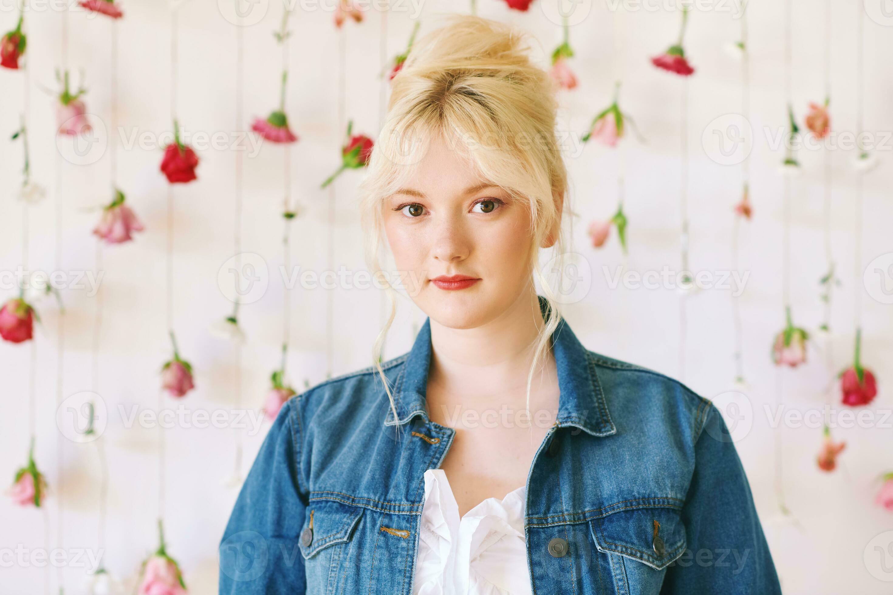 Studio portrait of pretty young teenage 15 - 16 year old girl wearing denim jacket, posing on ...