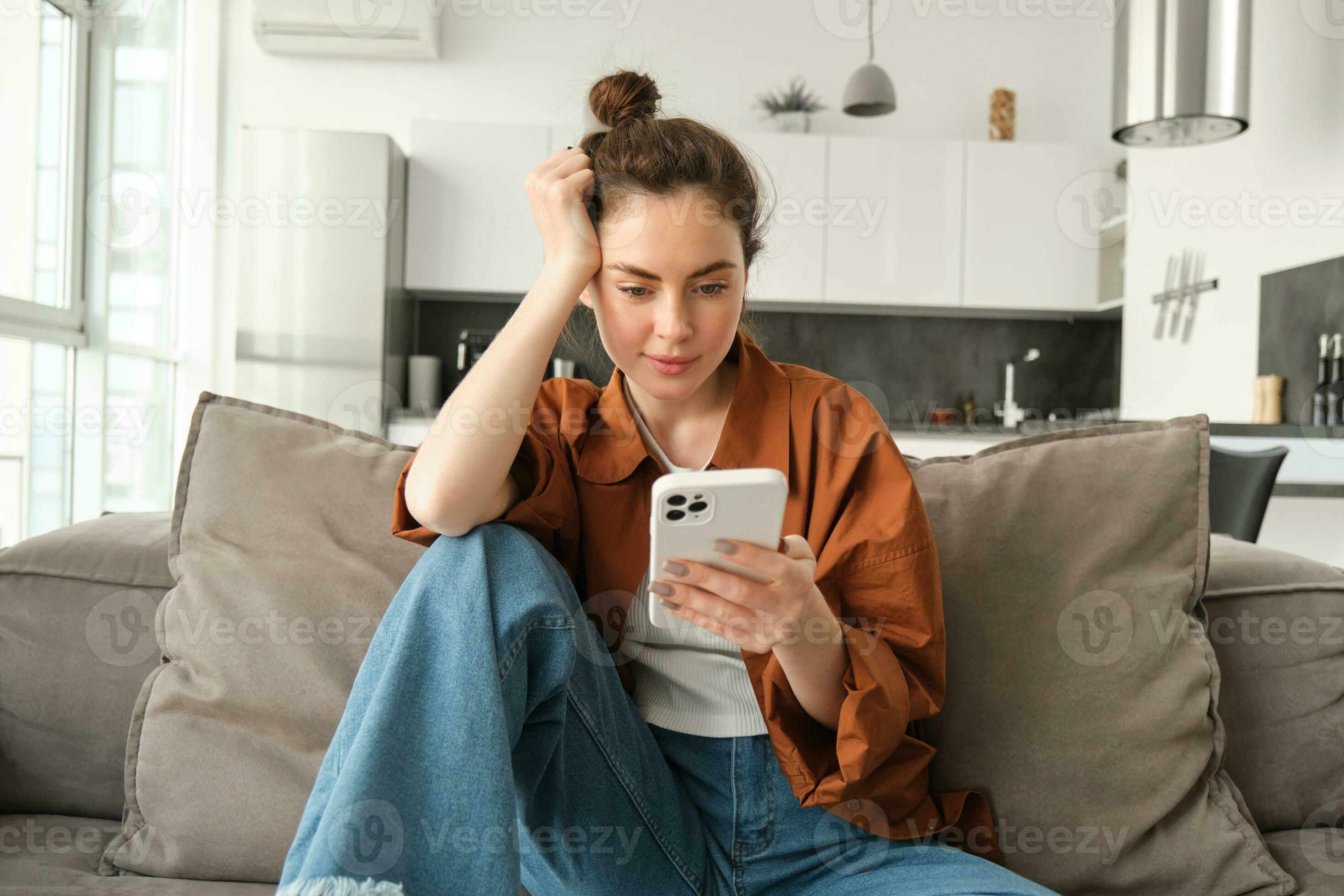 Portrait of young modern woman reading on mobile phone, scrolling social media app on smartphone ...