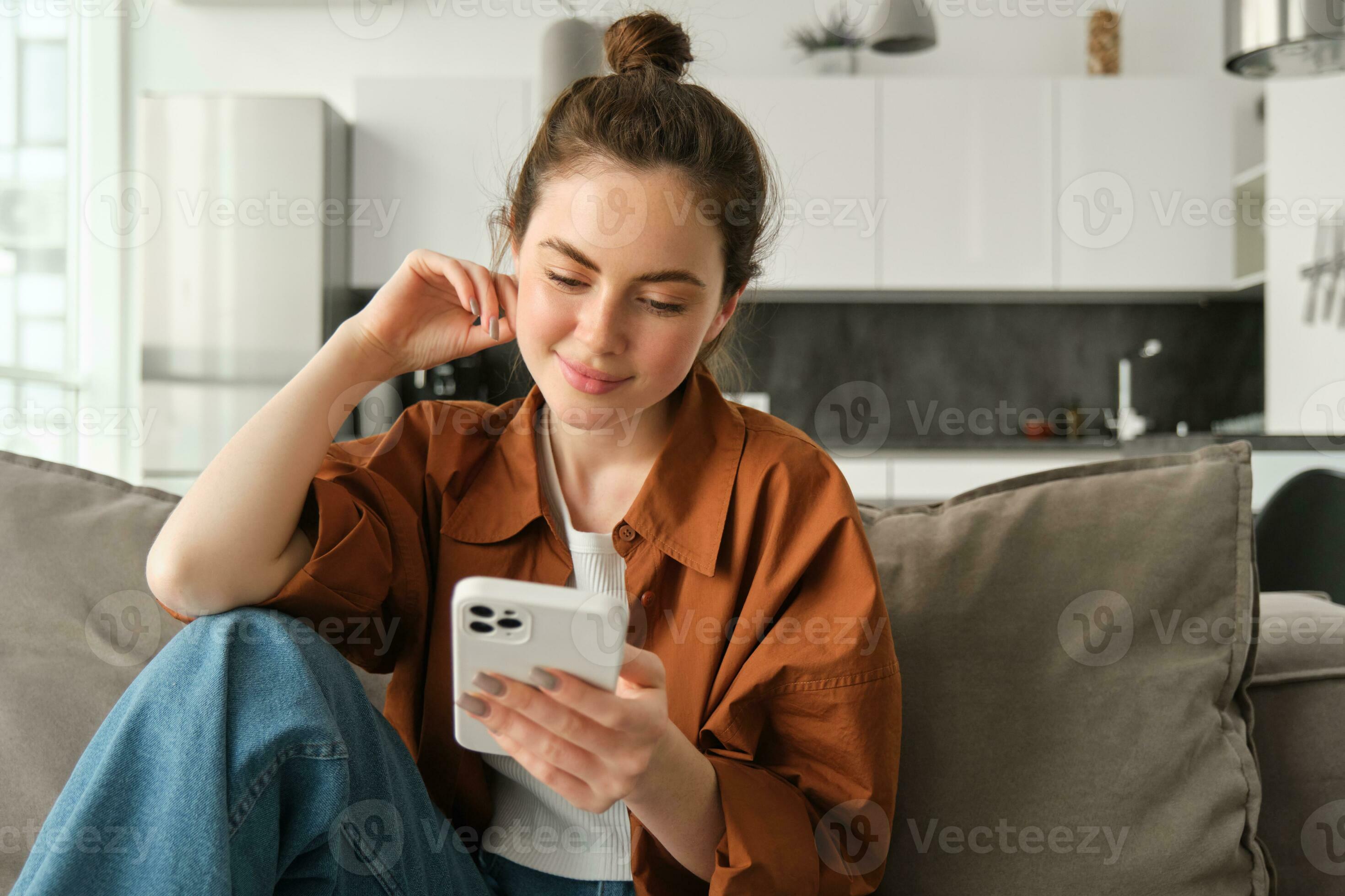Portrait of young modern woman reading on mobile phone, scrolling social media app on smartphone ...