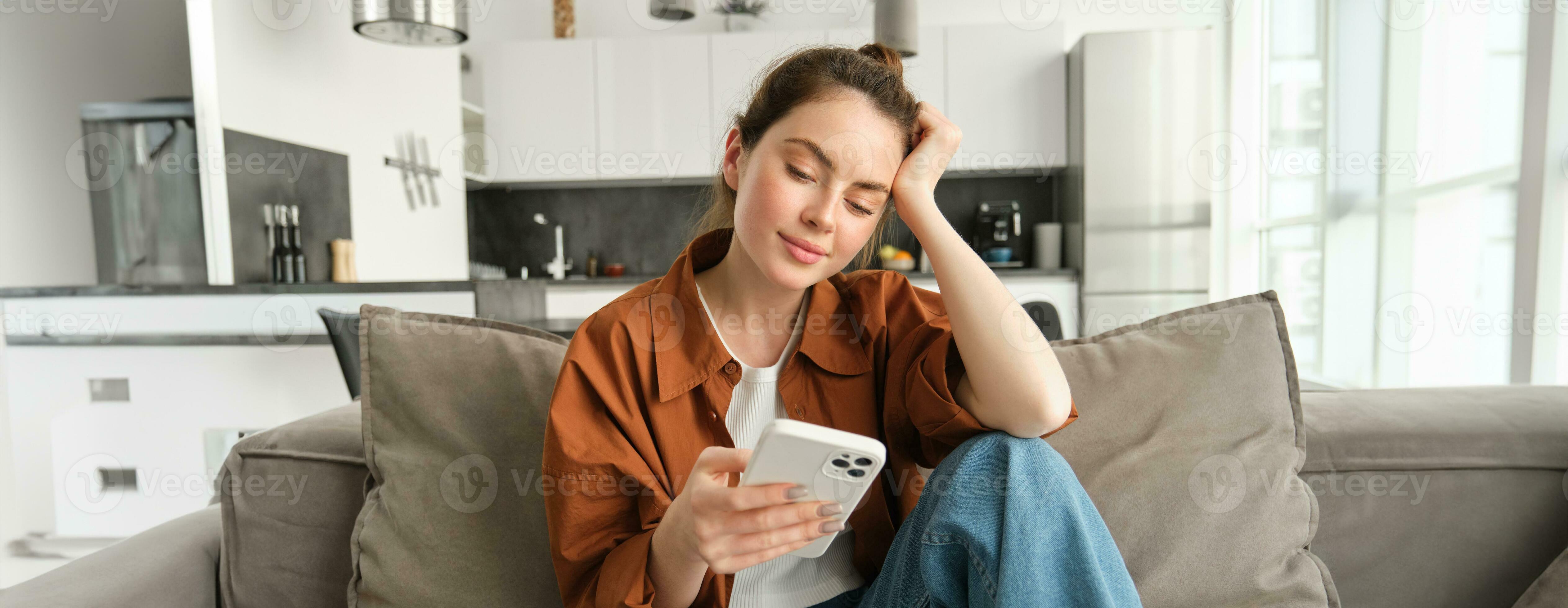 Portrait of young modern woman reading on mobile phone, scrolling social media app on smartphone ...