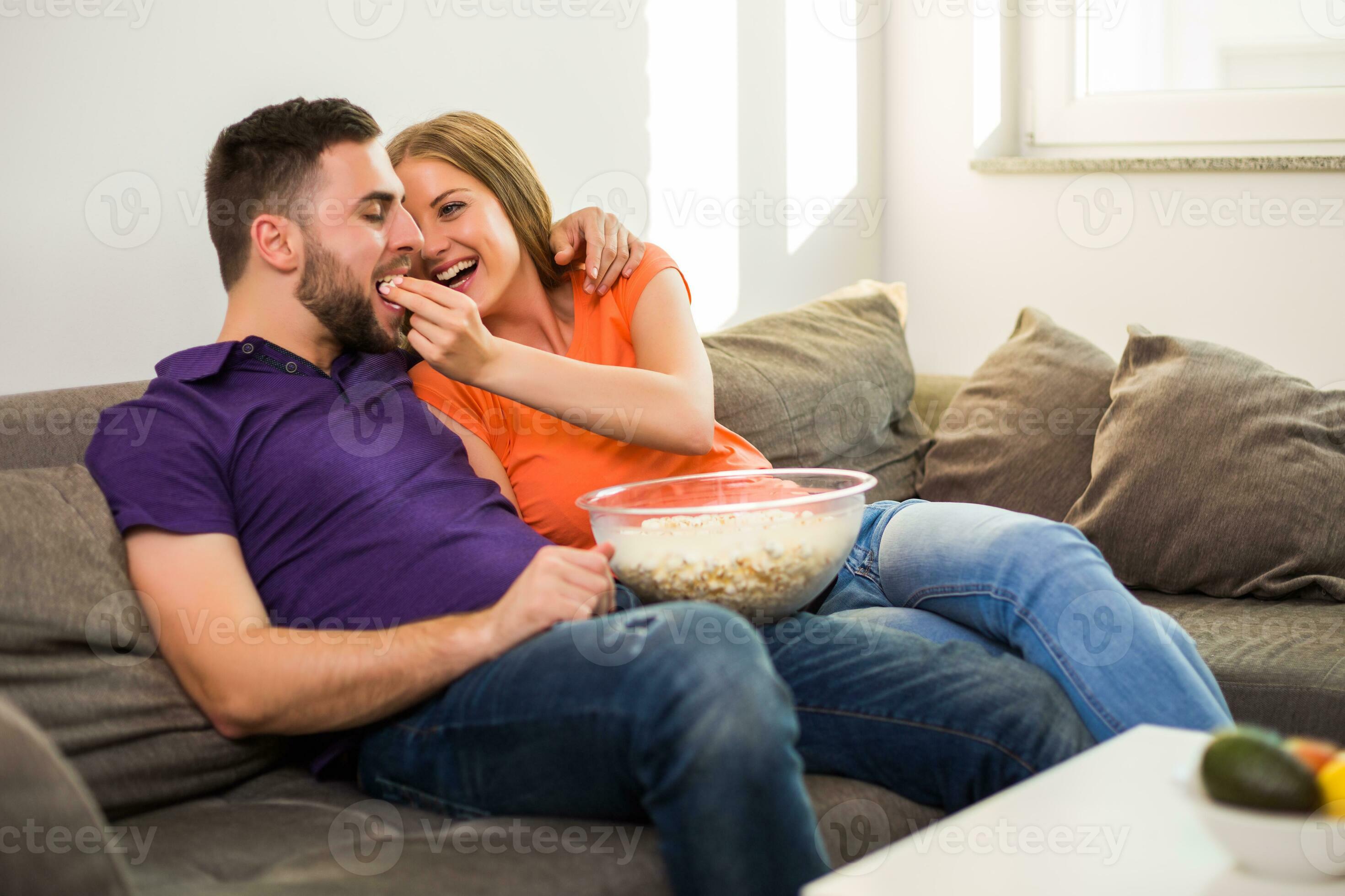 Happy Couple Enjoy Watching Tv Eating Popcorn And Spending Time