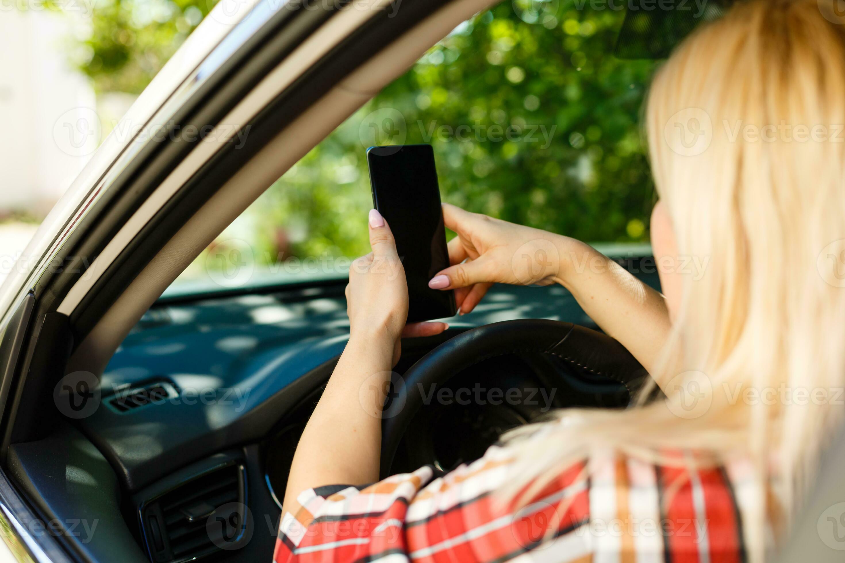 Young woman looks at her smartphone in a car. 35480265 Stock Photo at ...