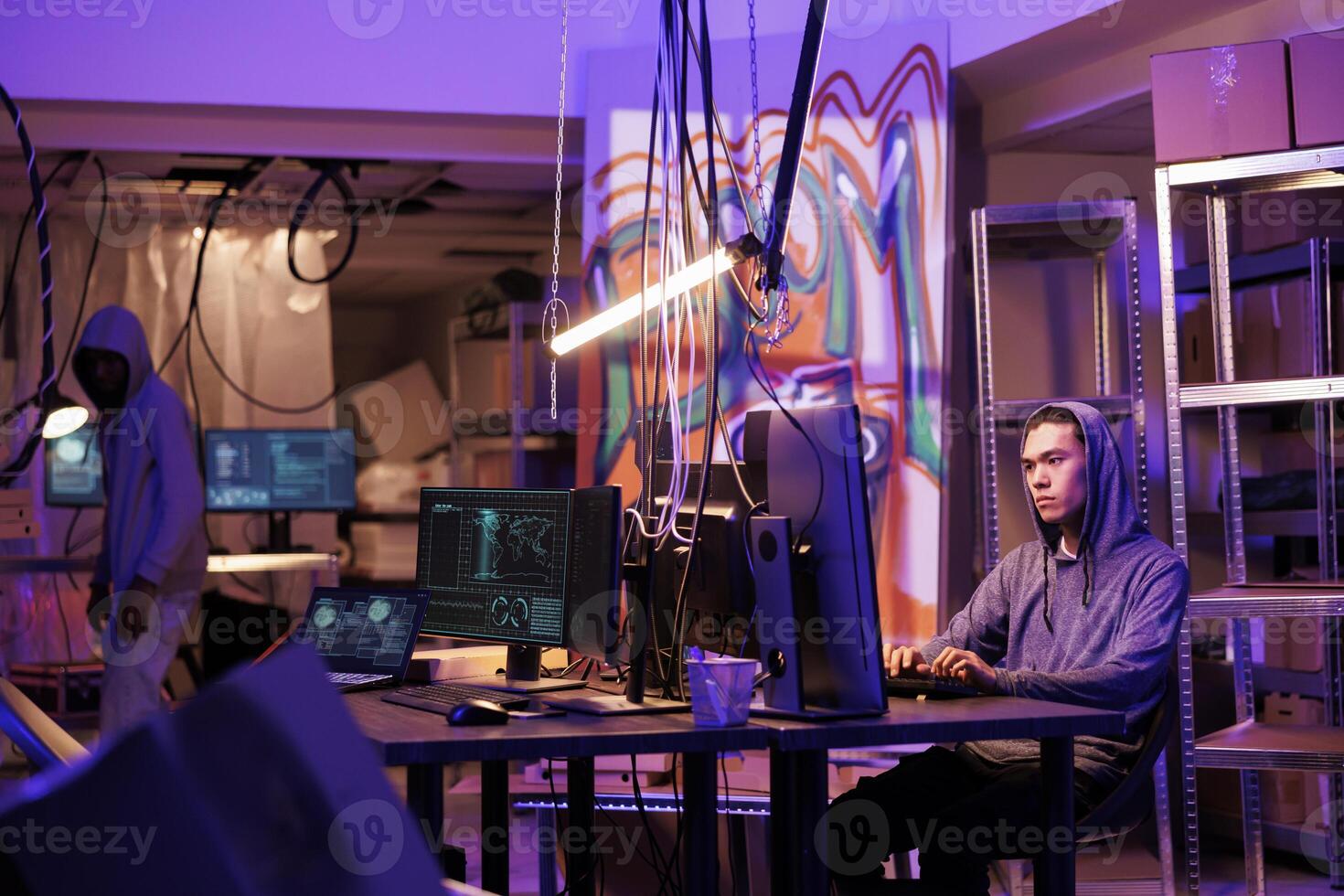 Young asian criminal using computer to hack system and planning cyberattack to steal data ...