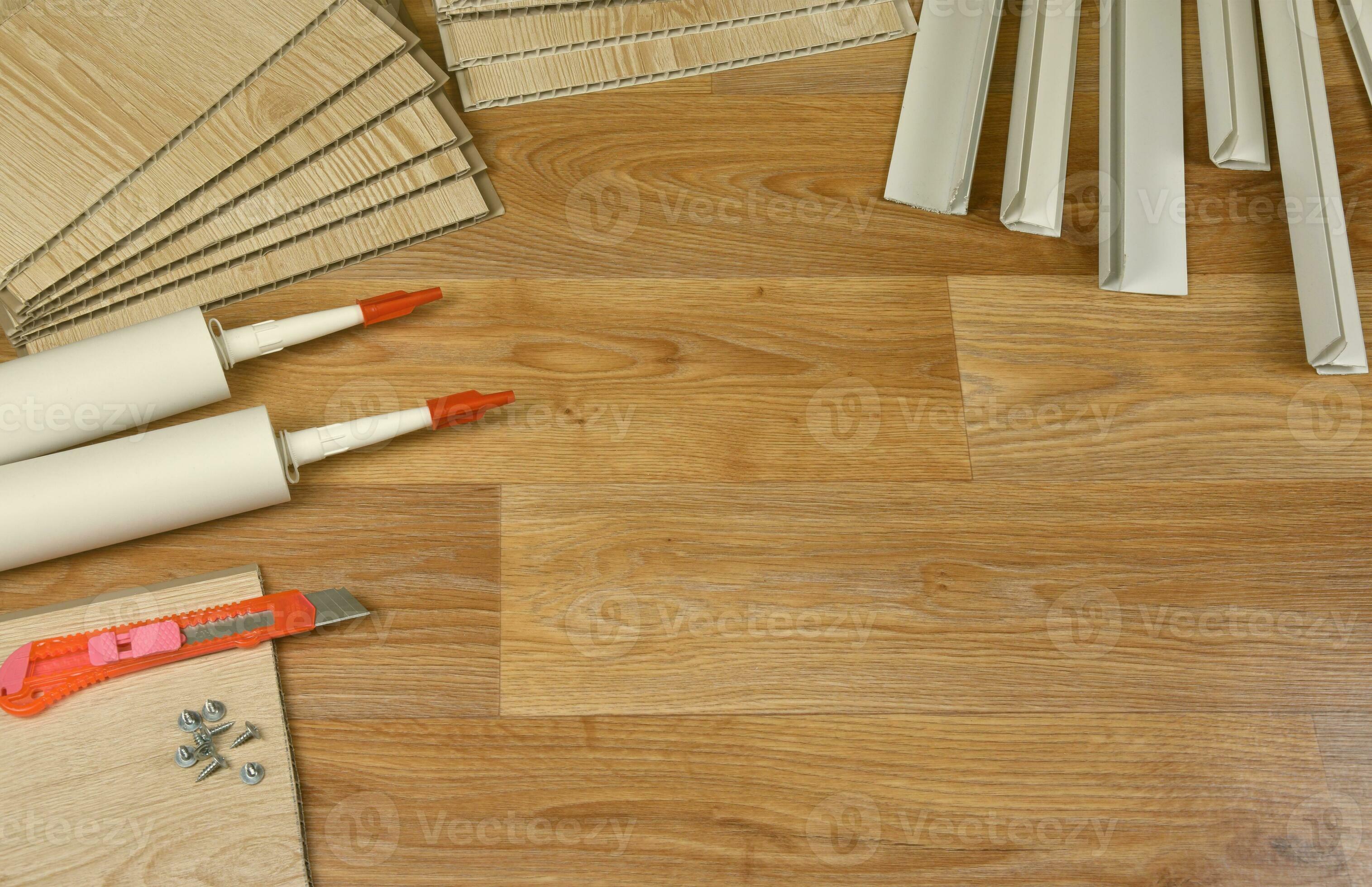 Set of items for PVC ceiling indoor works. Assembly adhesive bottles and PVC panels with plastic ...