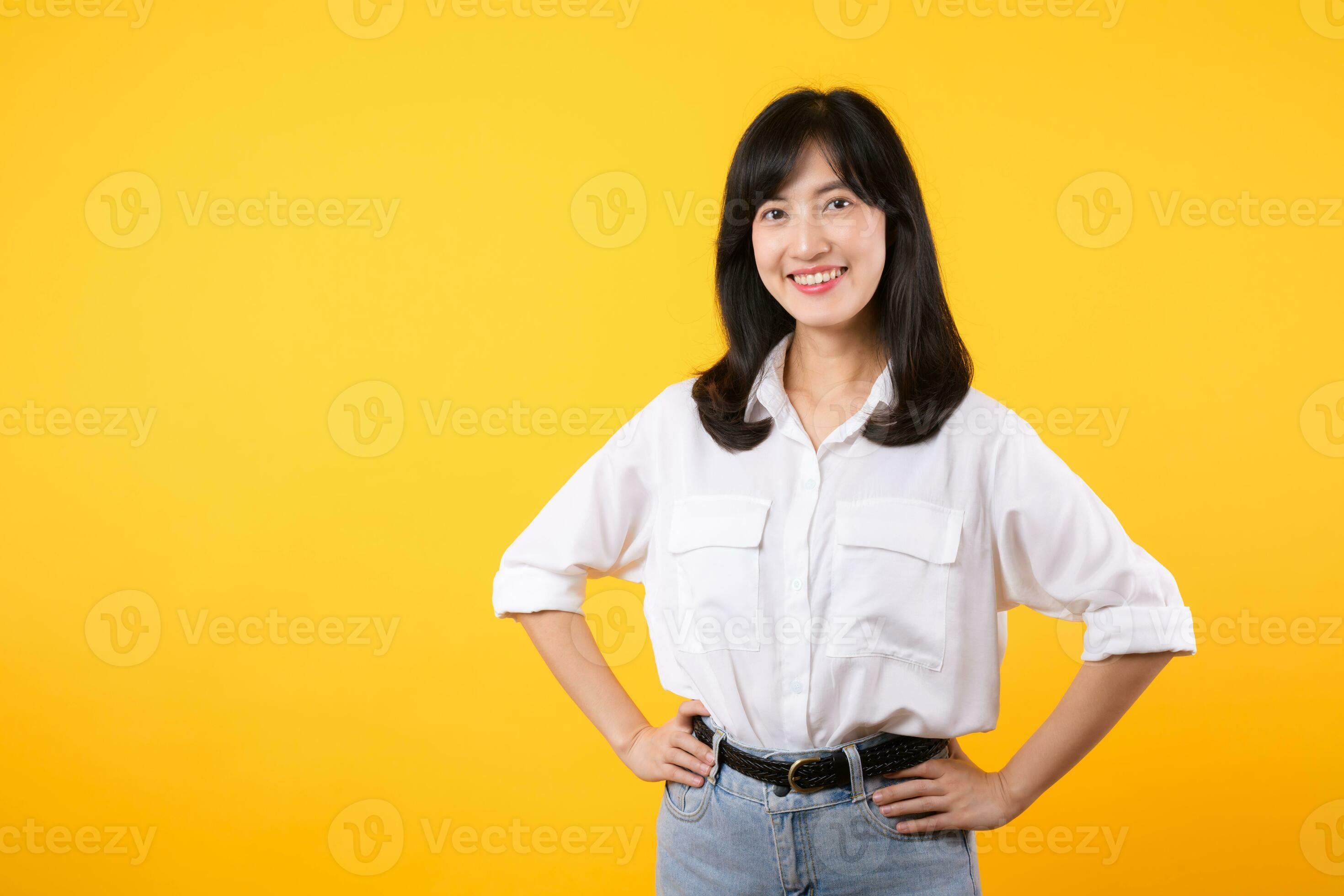 Portrait smiling young asian woman with arms akimbo Happy asia girl posing with arms on hips and ...