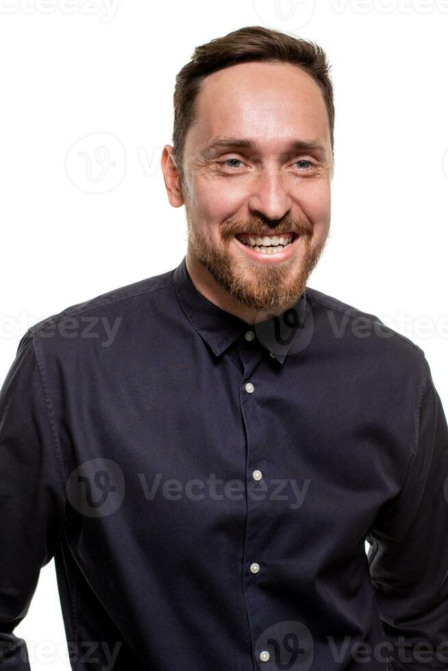Portrait of a handsome, unshaven man, dressed in a dark blue shirt ...