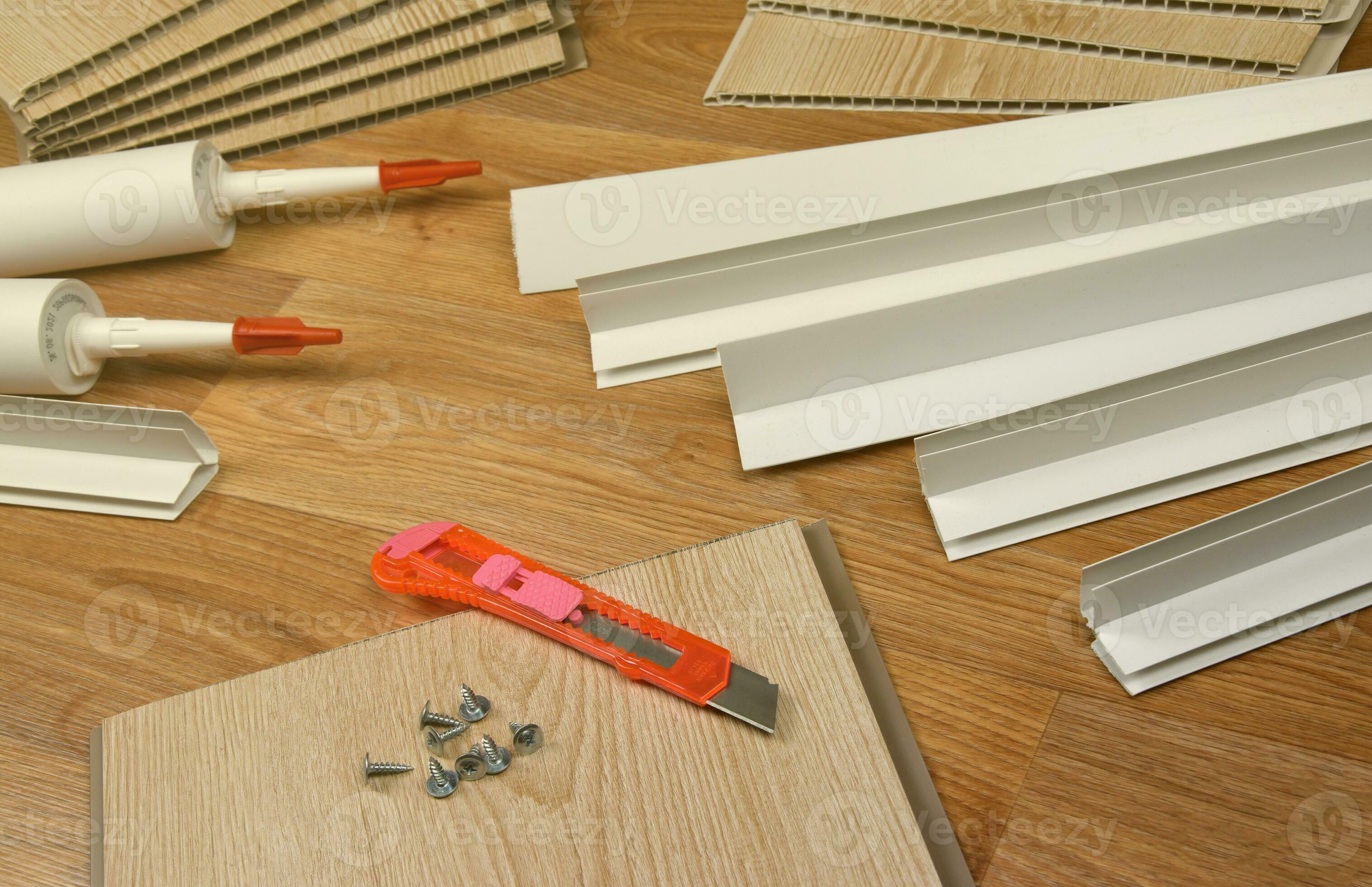 Set of items for PVC ceiling indoor works. Assembly adhesive bottles and PVC panels with plastic ...