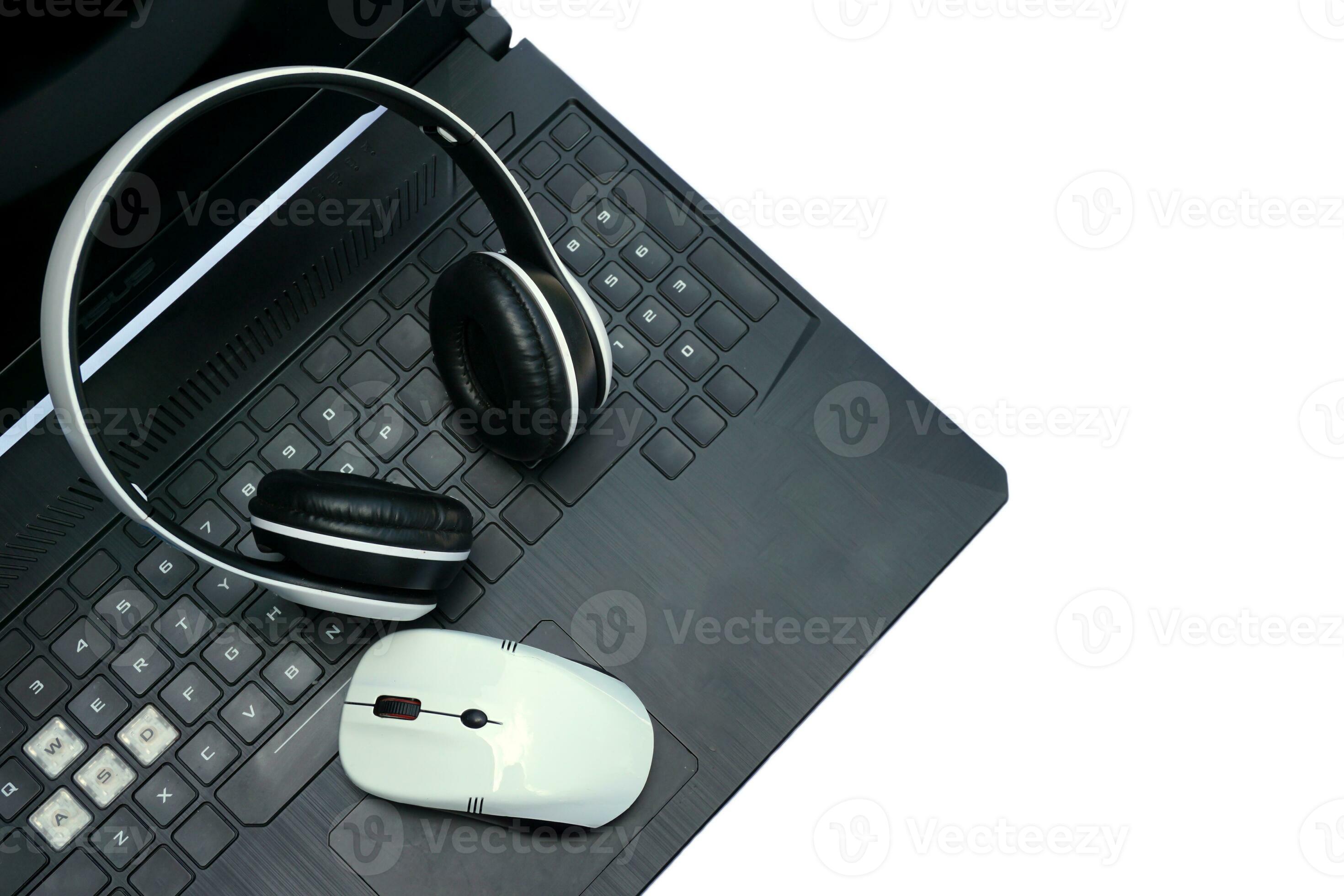 Top view of mouse, wireless headphones, placed on notebook computer keyboard which is a device ...