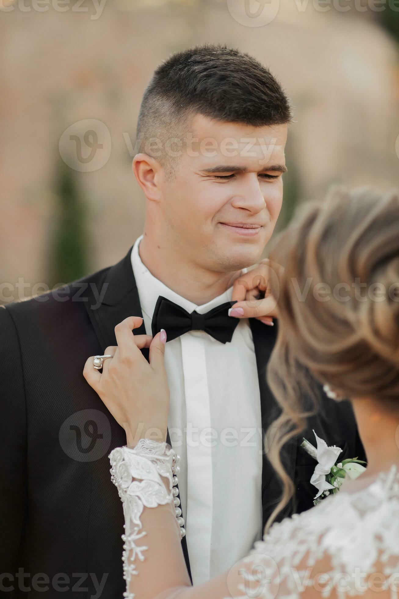 Portrait. A man in a white shirt, black bow tie, and black suit looks ...