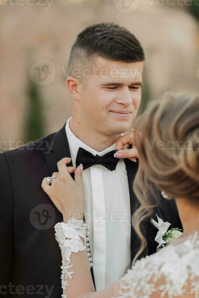 Portrait. A man in a white shirt, black bow tie, and black suit looks ...