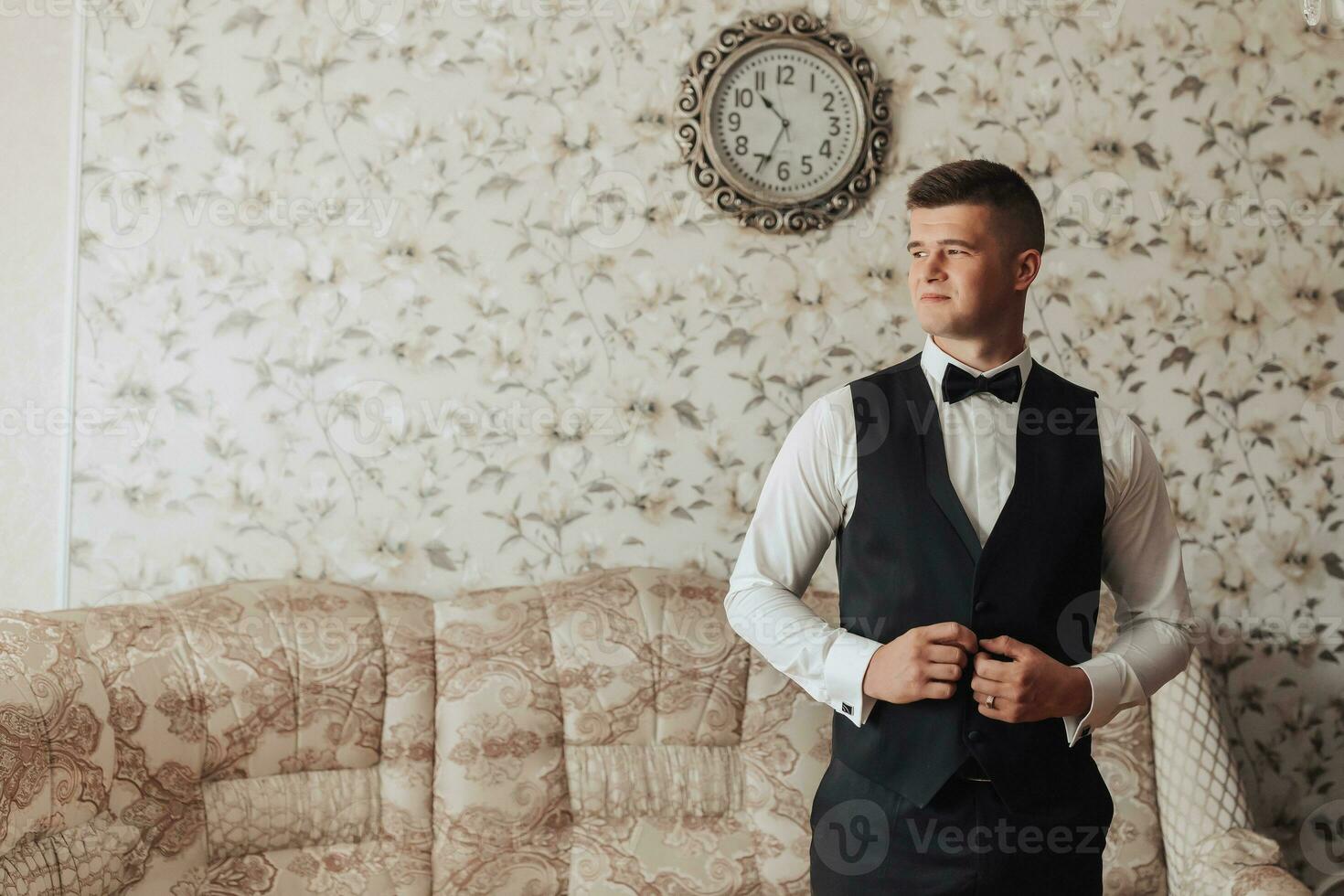 Portrait. A man in a white shirt, black bow tie and black pants and ...