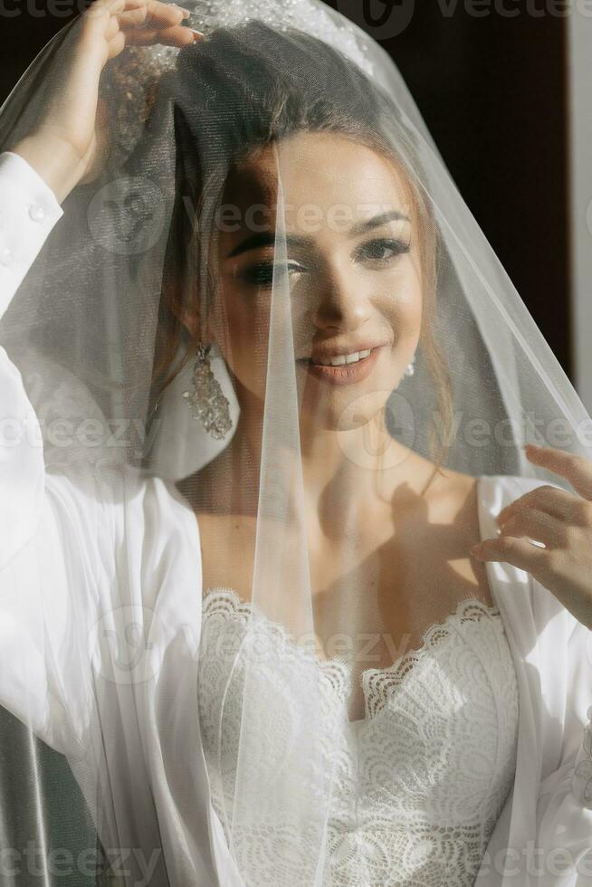 Happy beautiful bride under veil closeup. Beautiful bride shows makeup ...